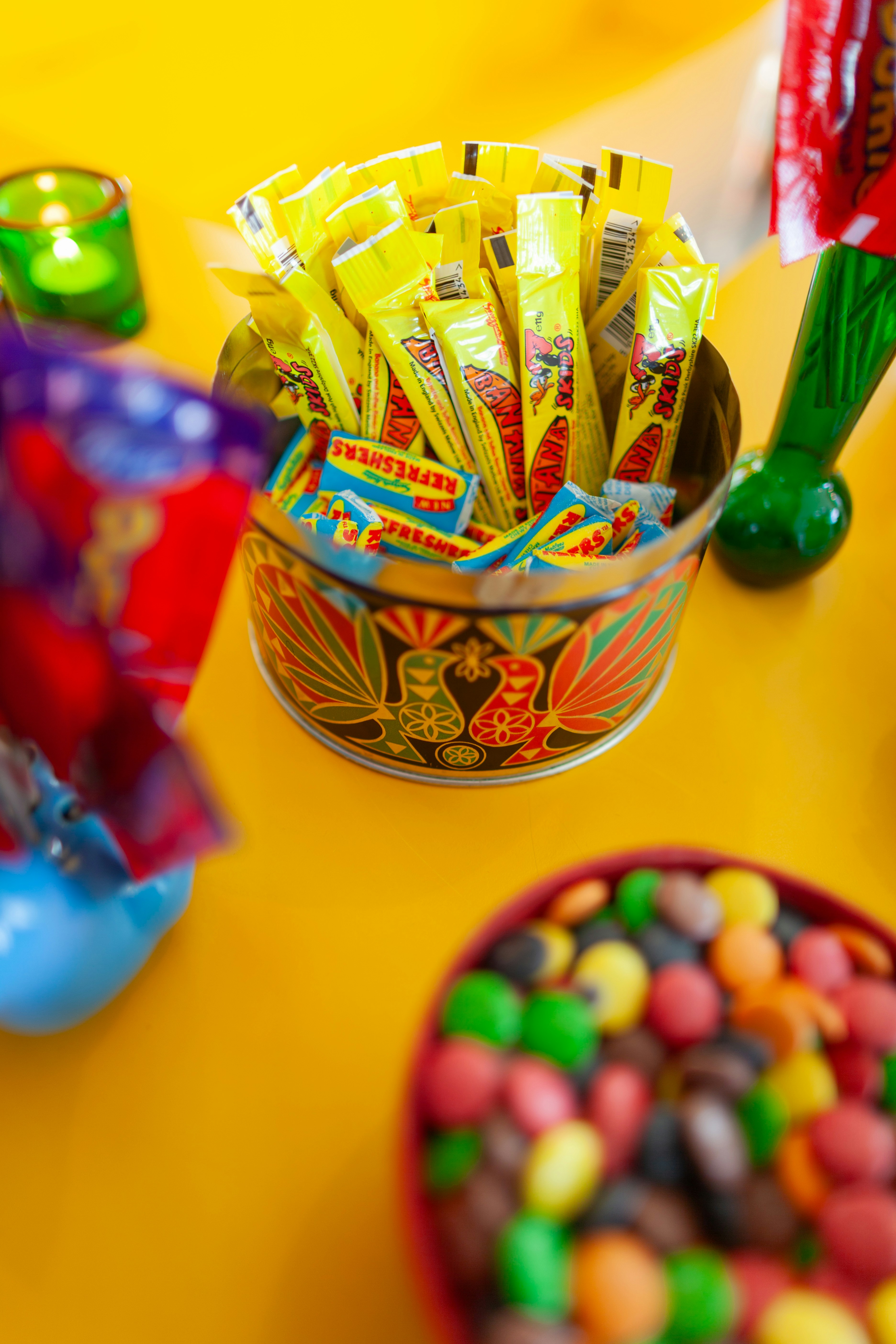 Candy tin at the center of a sunlit snack-desk scene