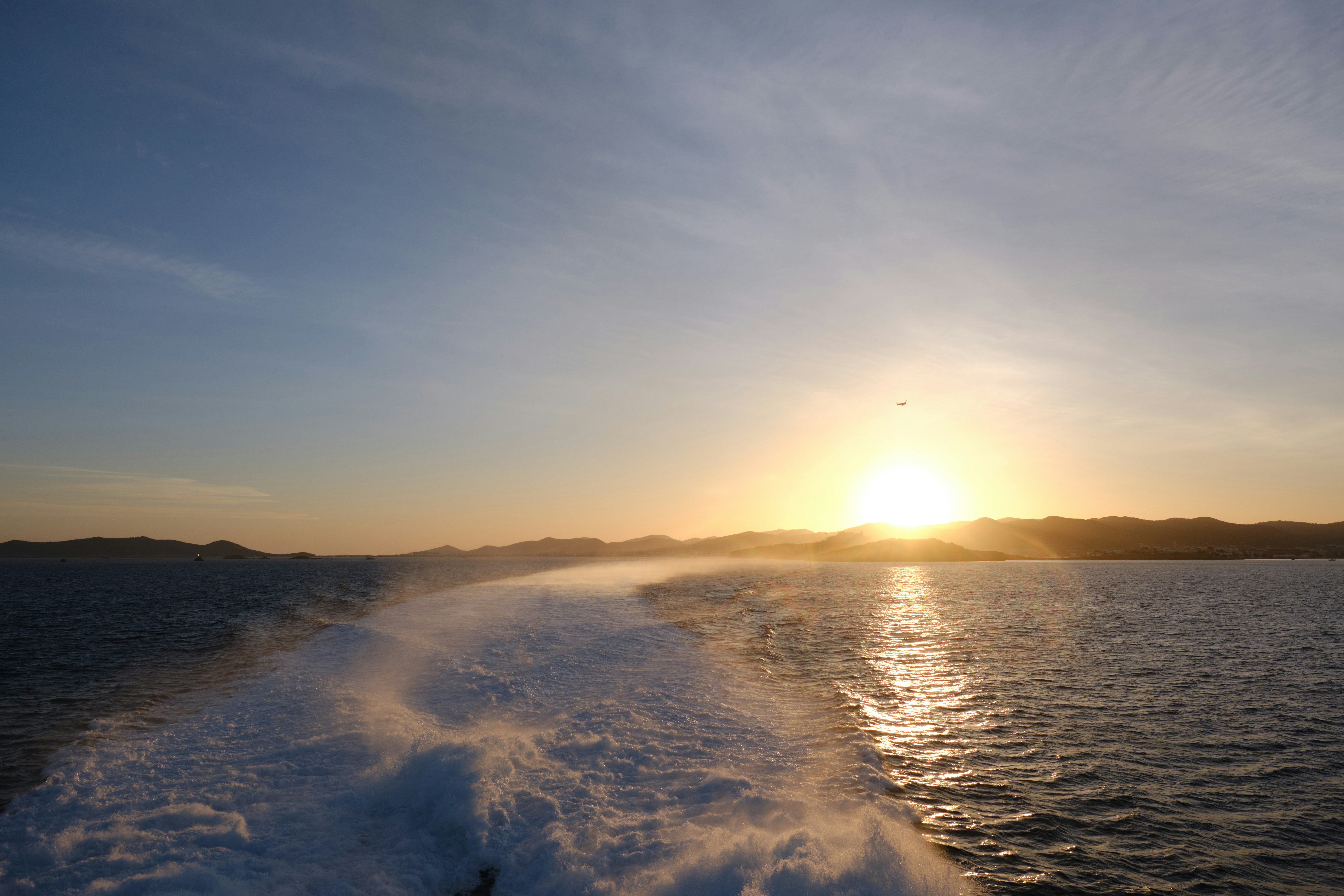 Sunlit Wake: A Vessel’s Trail Across Quiet Seas