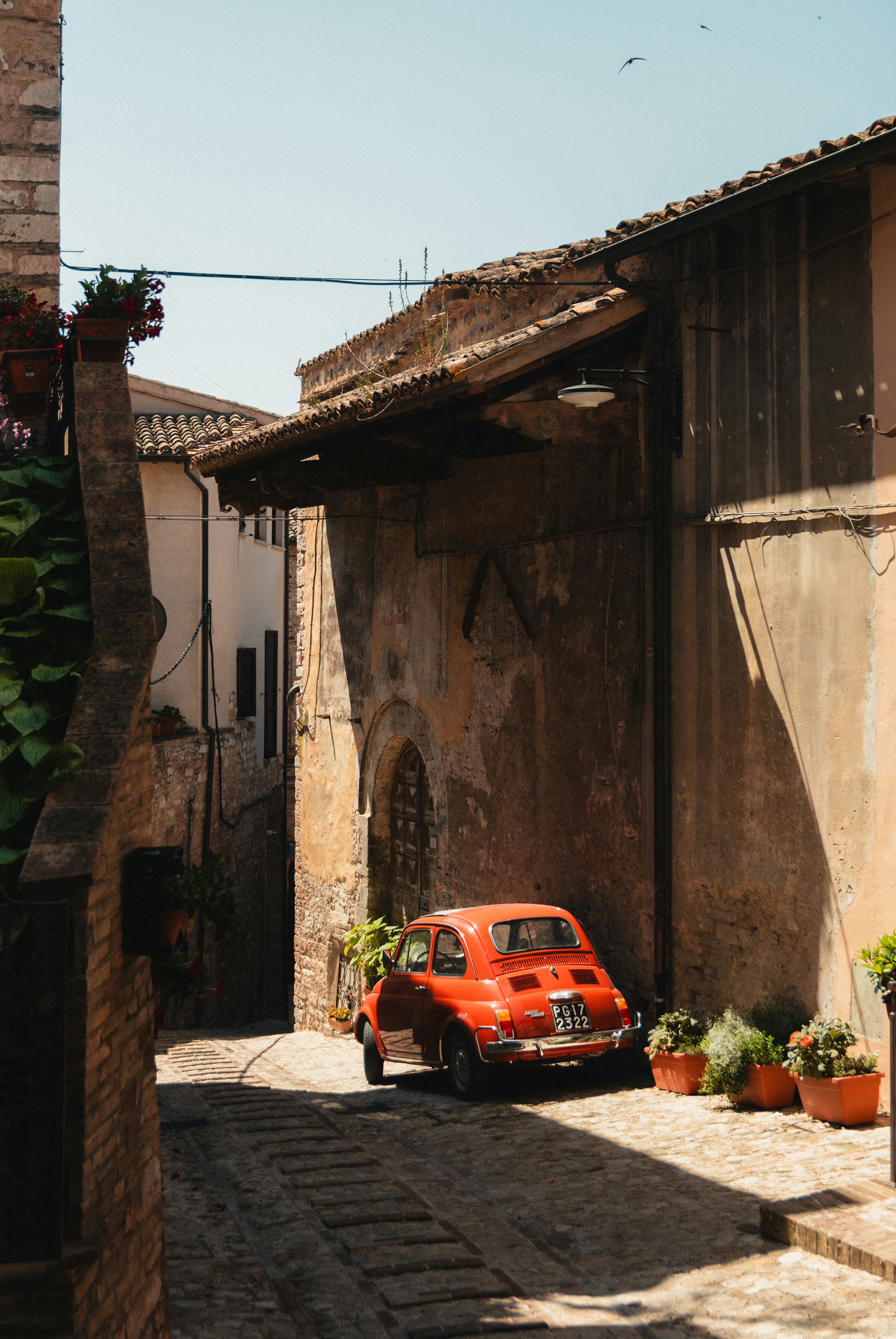 Red Fiat in a Sunlit European Alley