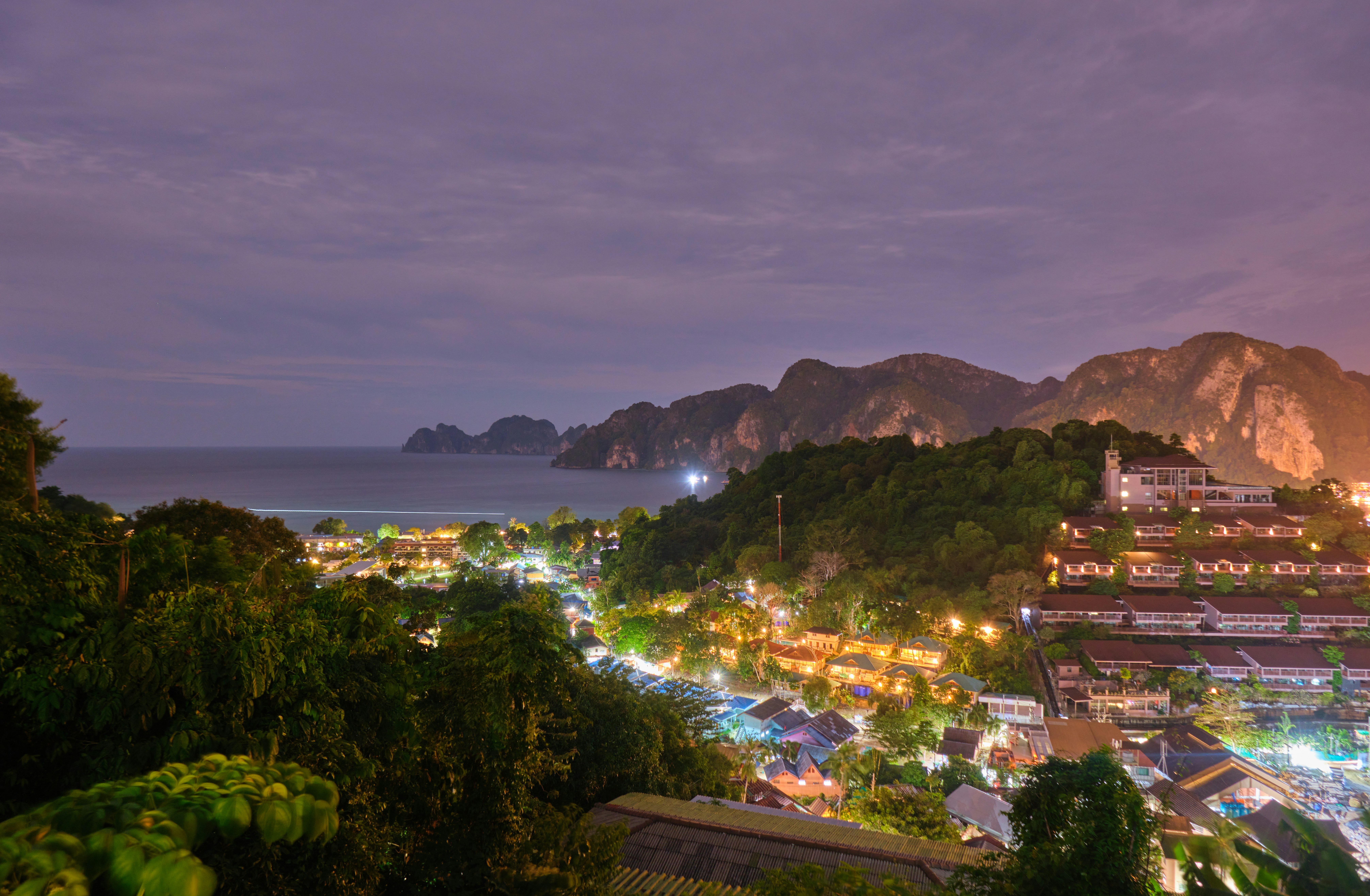 Night Coastline Lights Bloom Over a Hillside Village