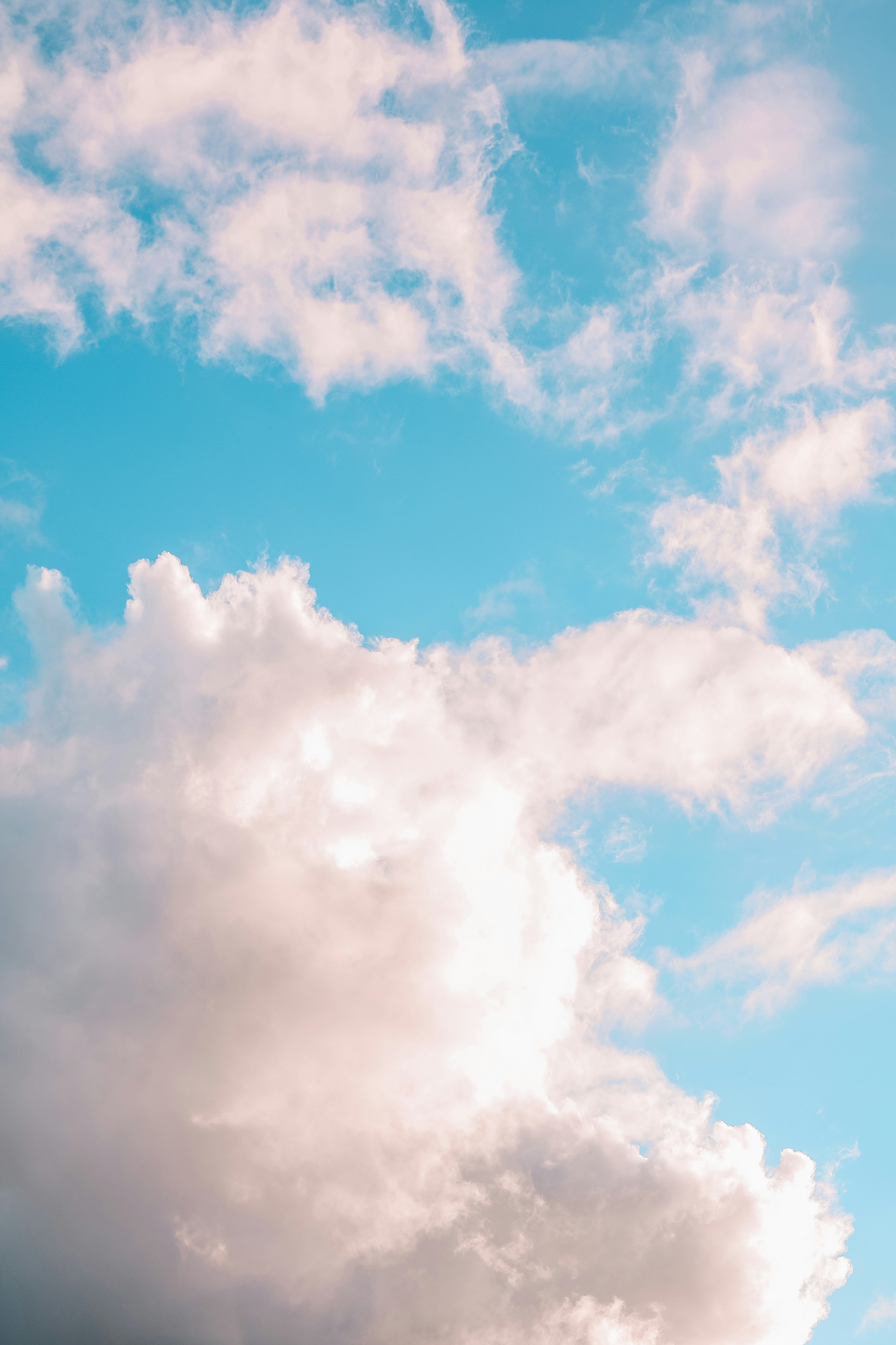Skybound Formations: Sunlit Clouds Against a Clear Blue Vista
