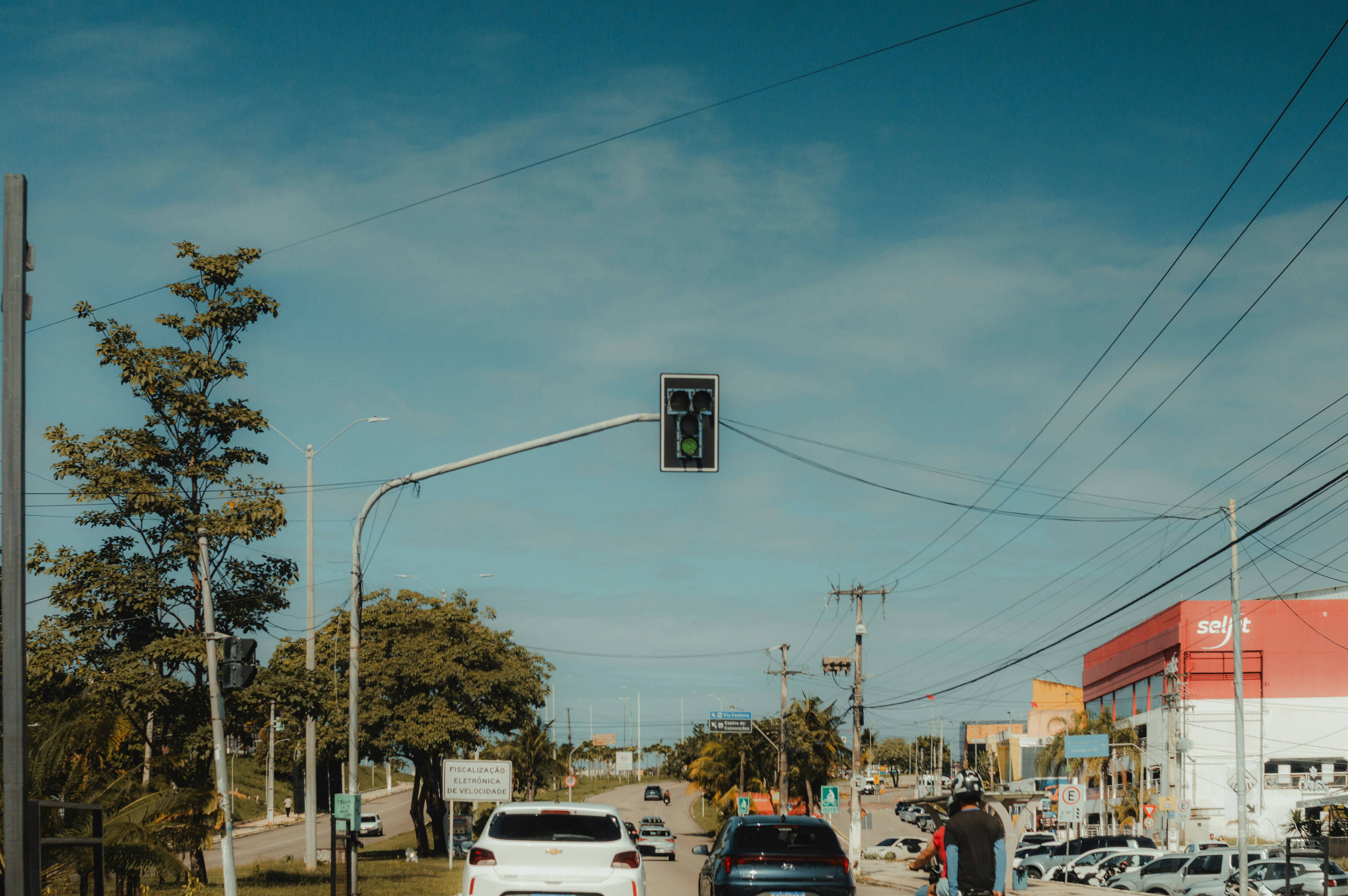 City Intersection Quietly Busy Beneath a Wide Blue Sky