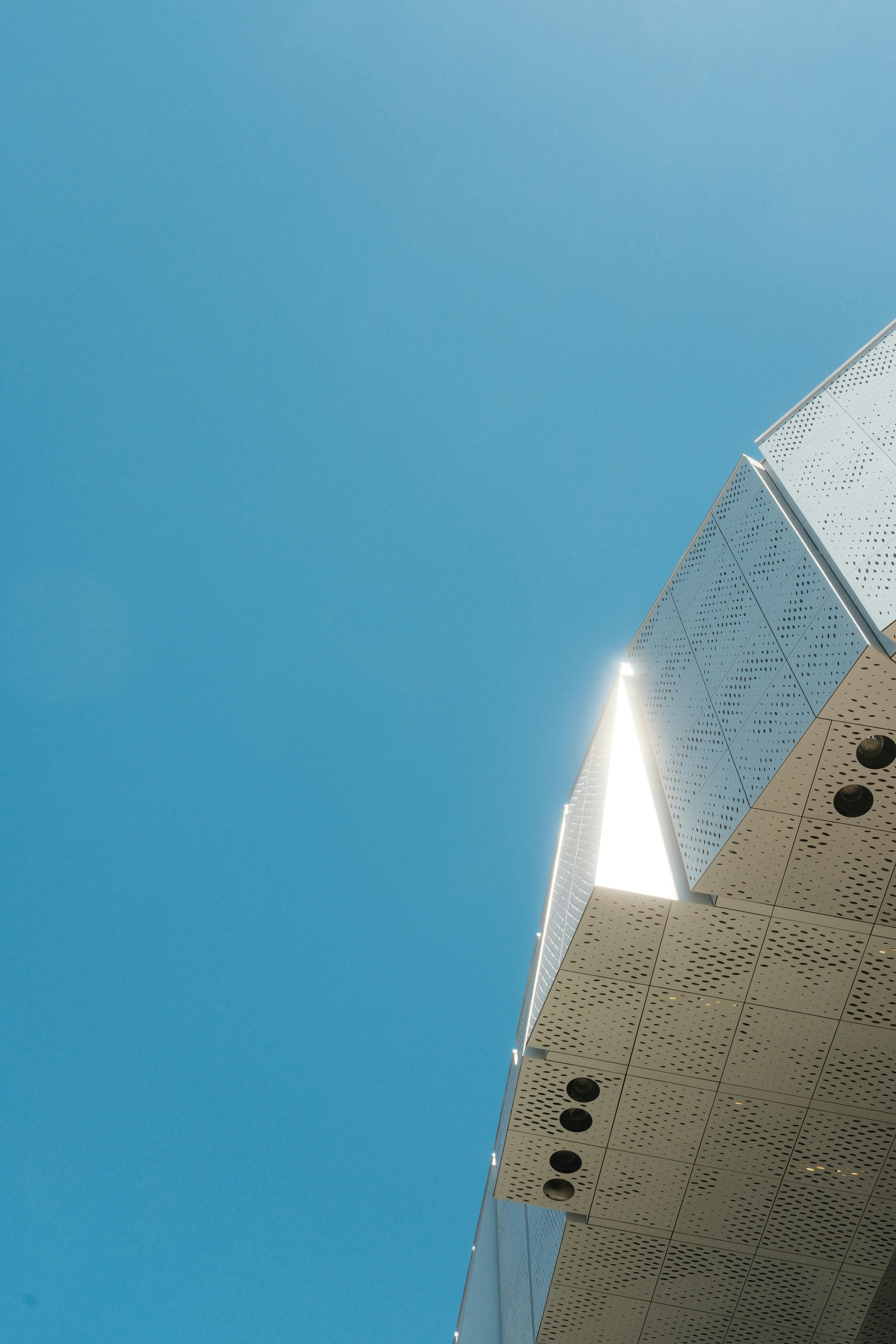 Architectural Edge: Steel Facade Piercing a Clear Sky