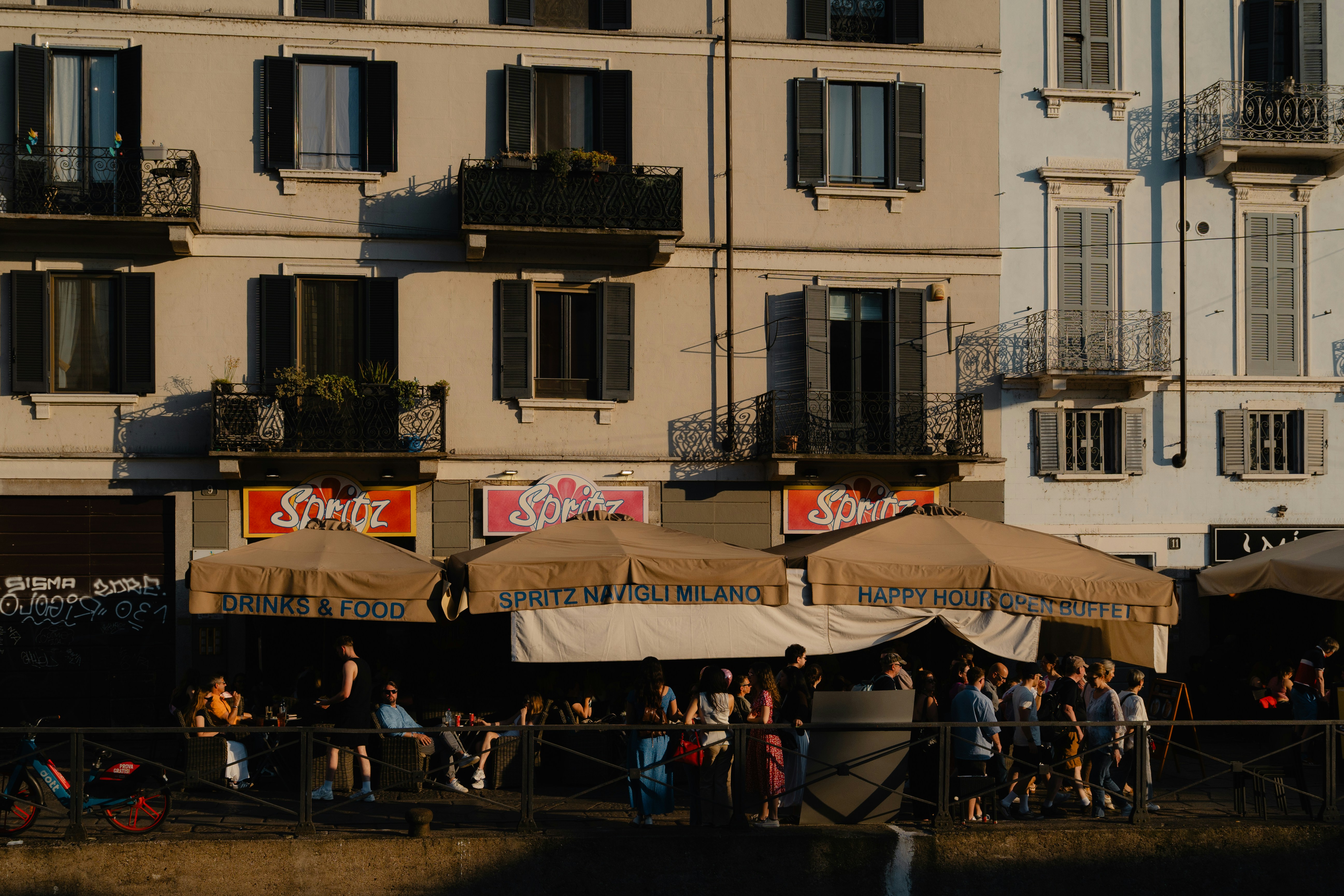 Cafe by the Canal: Sunlit Terrace Beneath Urban Facades
