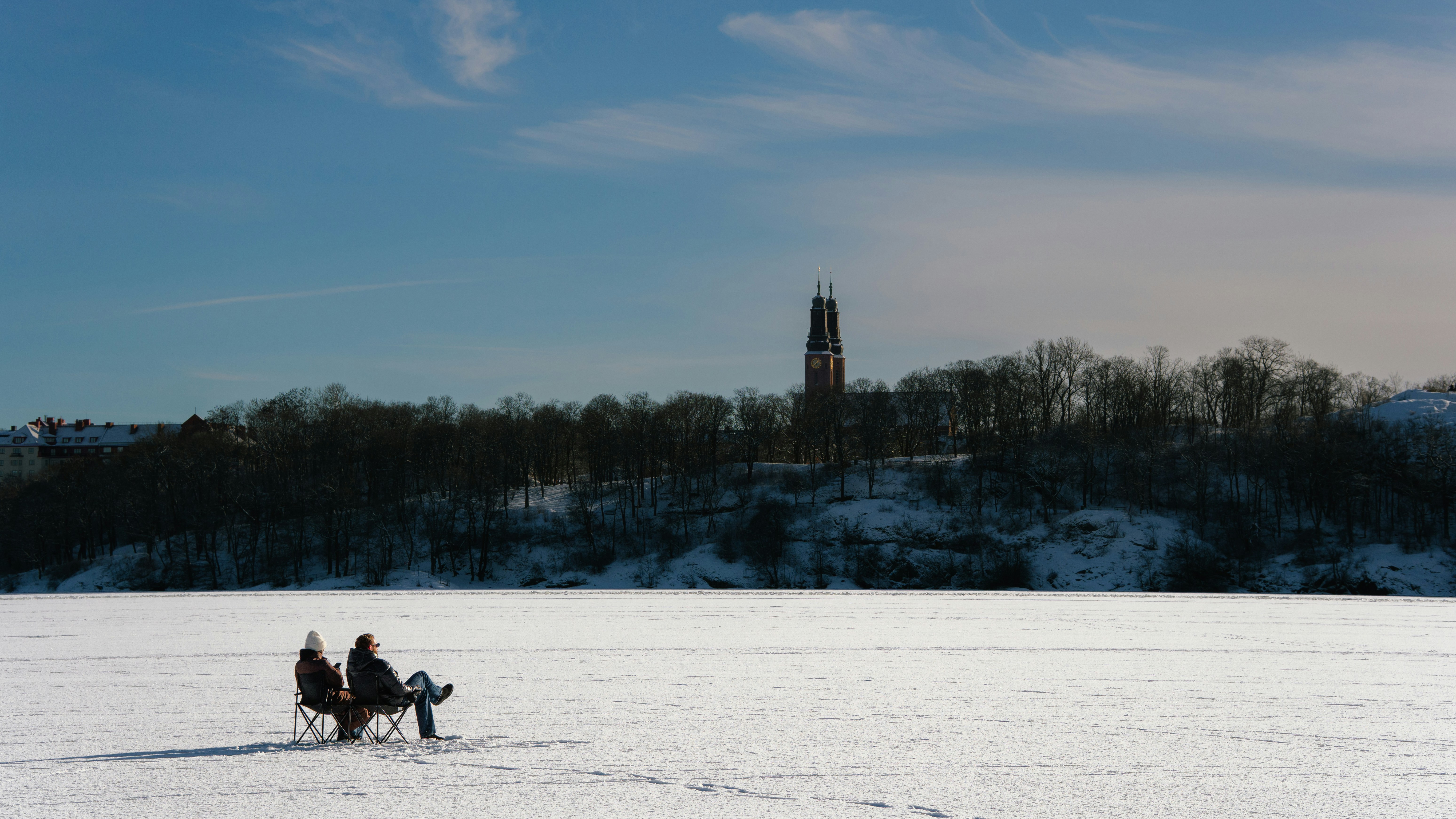 Snowbound Figures Under a Distant Tower