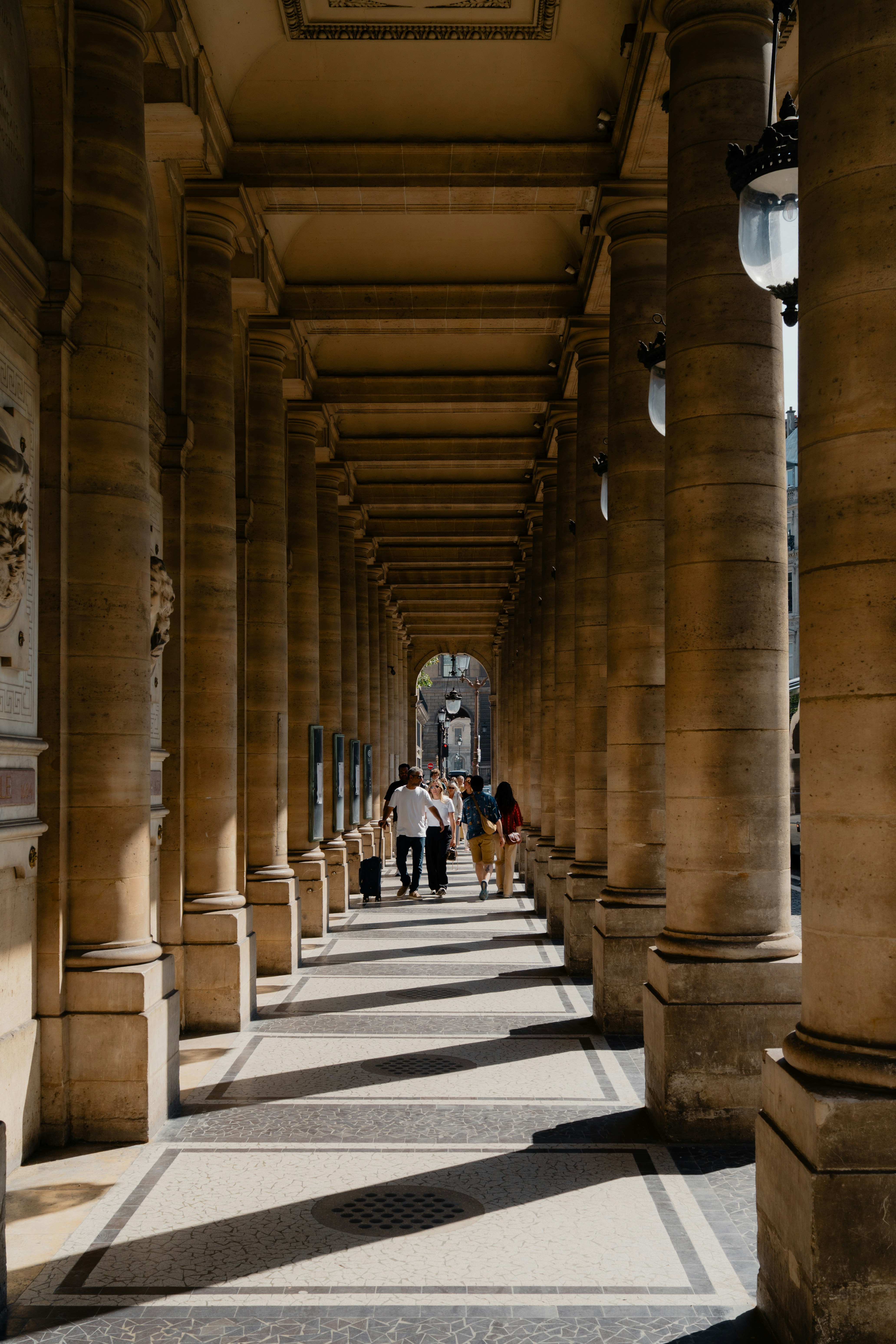 Colonnaded Pathway: People Walking Toward a Distant Arch