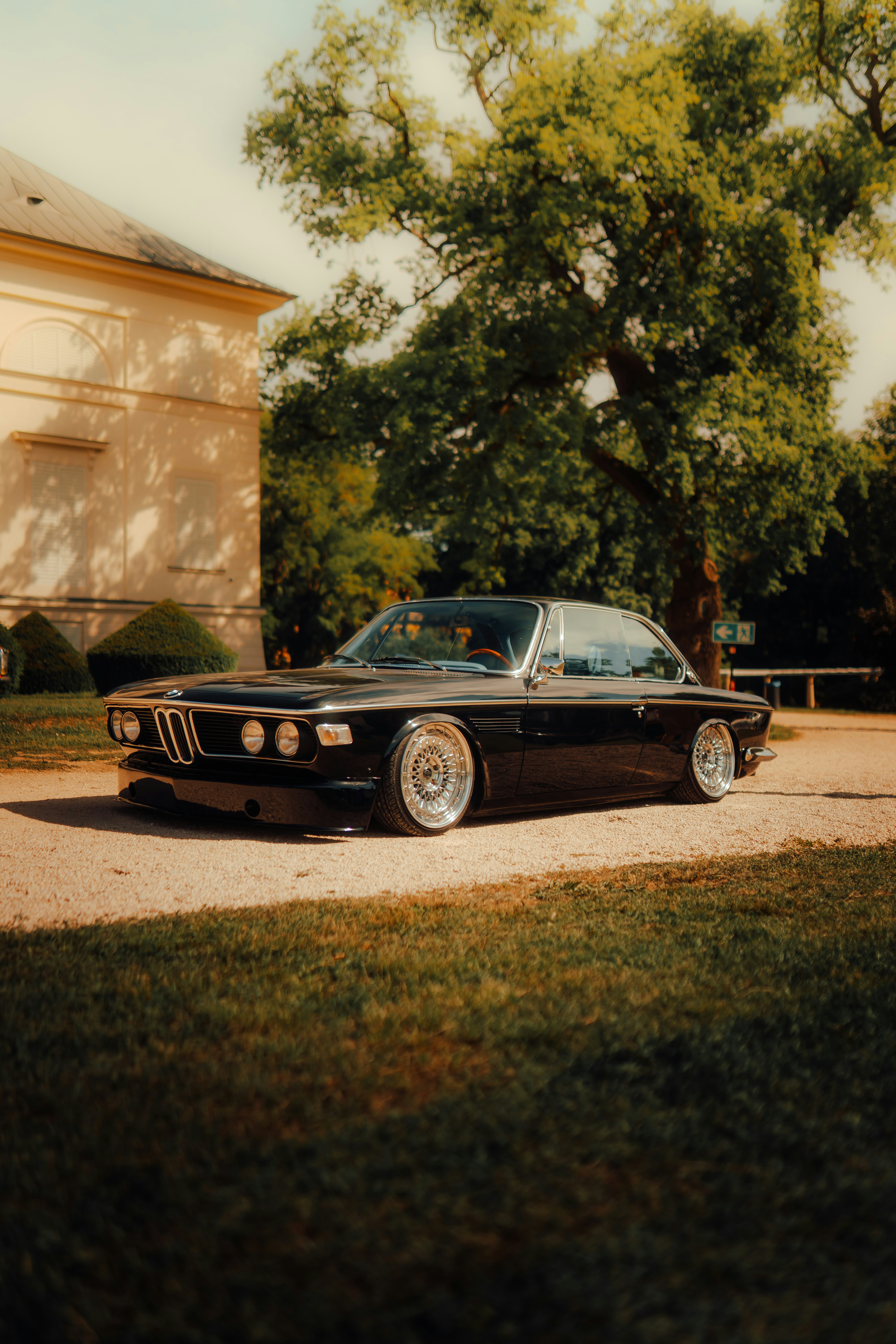 Low-Slung Black Classic: A Buick-era Silhouette Resting on Rustic Gravel
