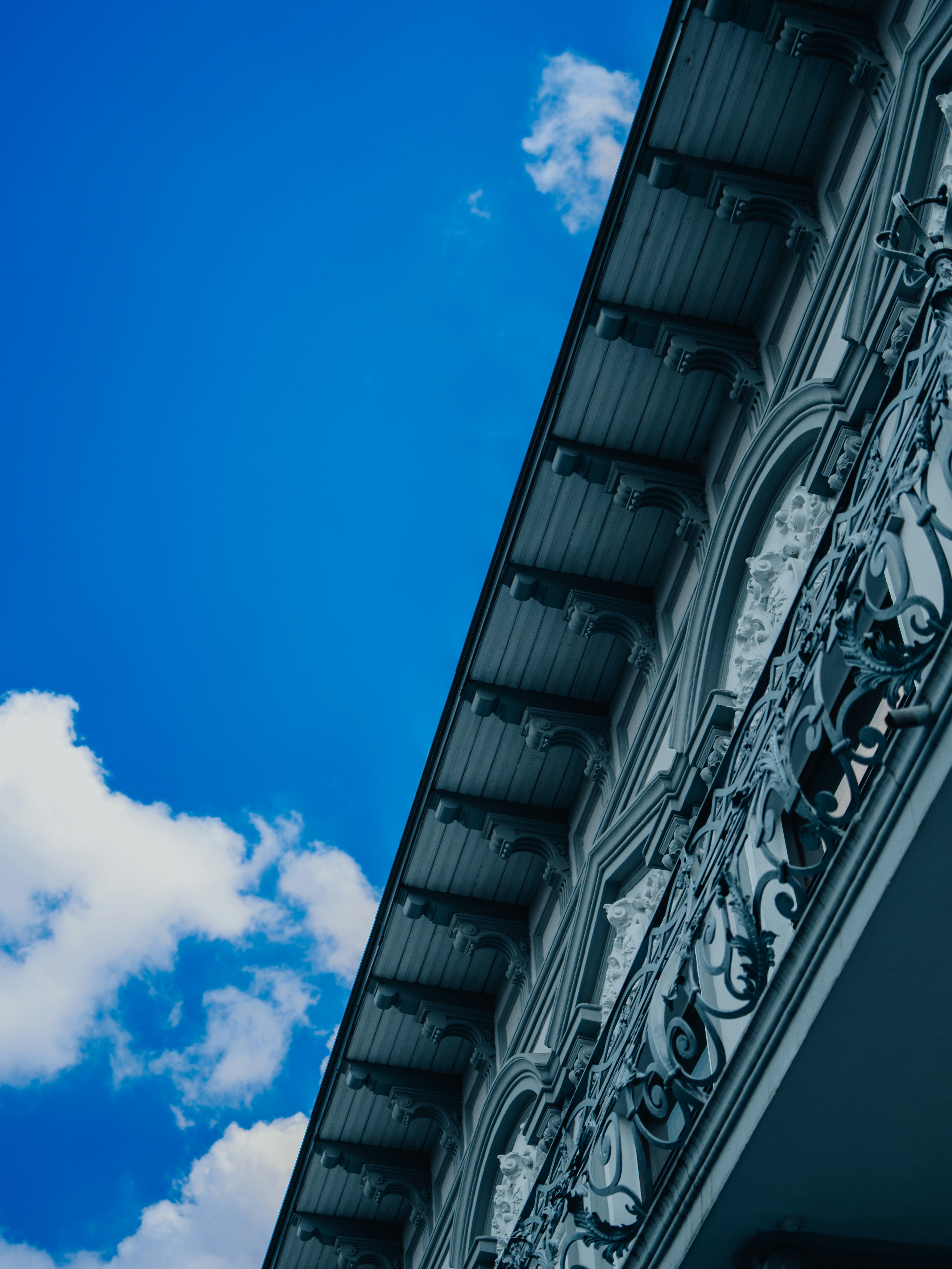 Ornate Balcony Edge Reaching Toward a Blue Sky
