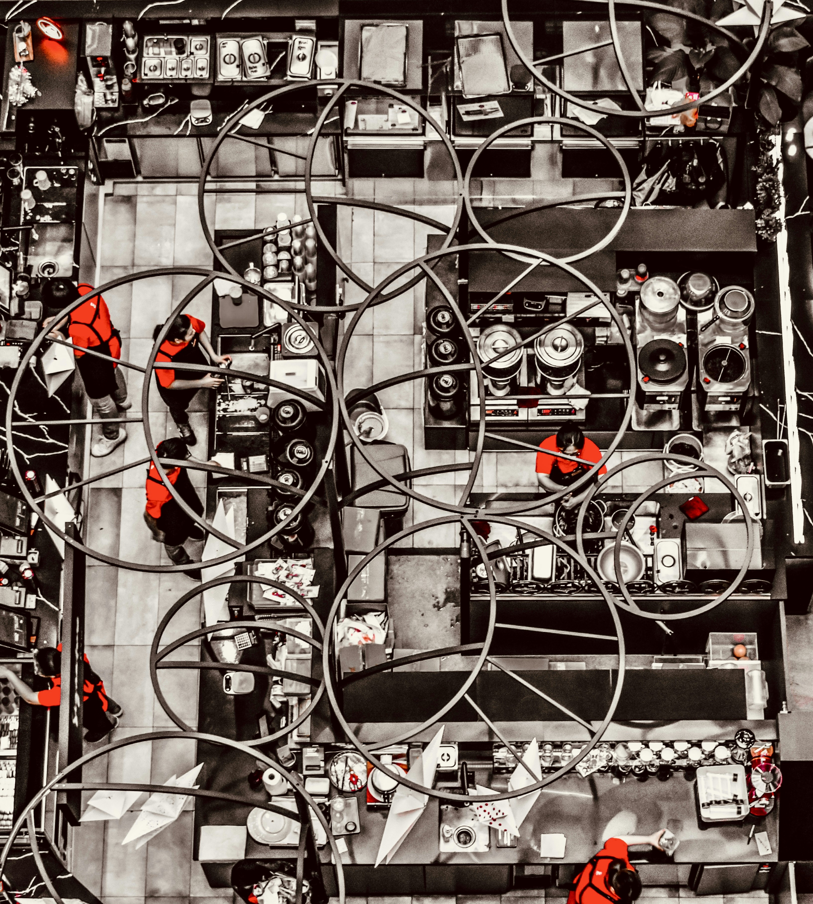 Overhead Tangle: Red Uniforms Anchor a Labyrinth of Cables and Concoctions