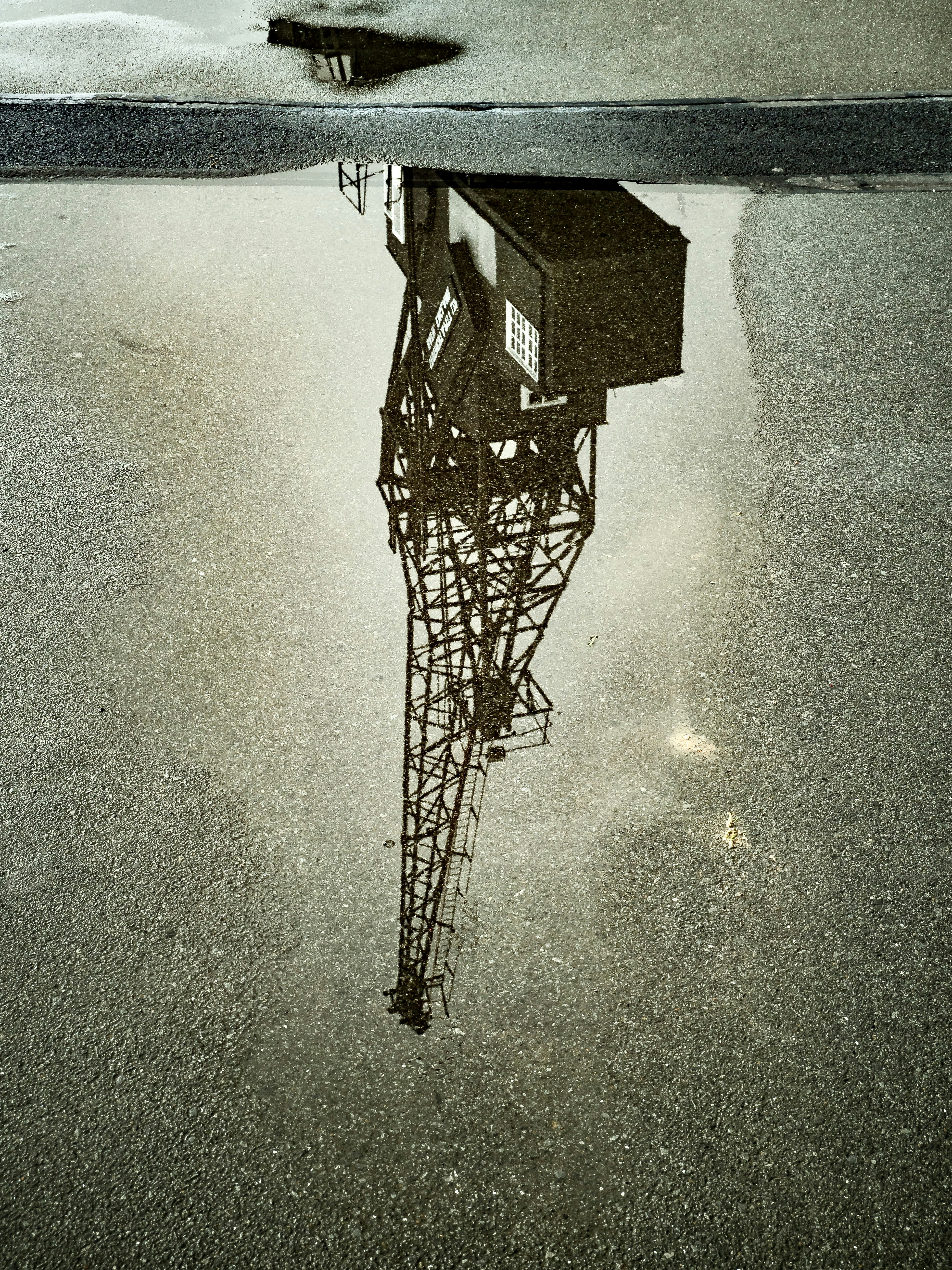 Industrial Lattice Reversed: A Crane’s Silhouette in Wet Concrete