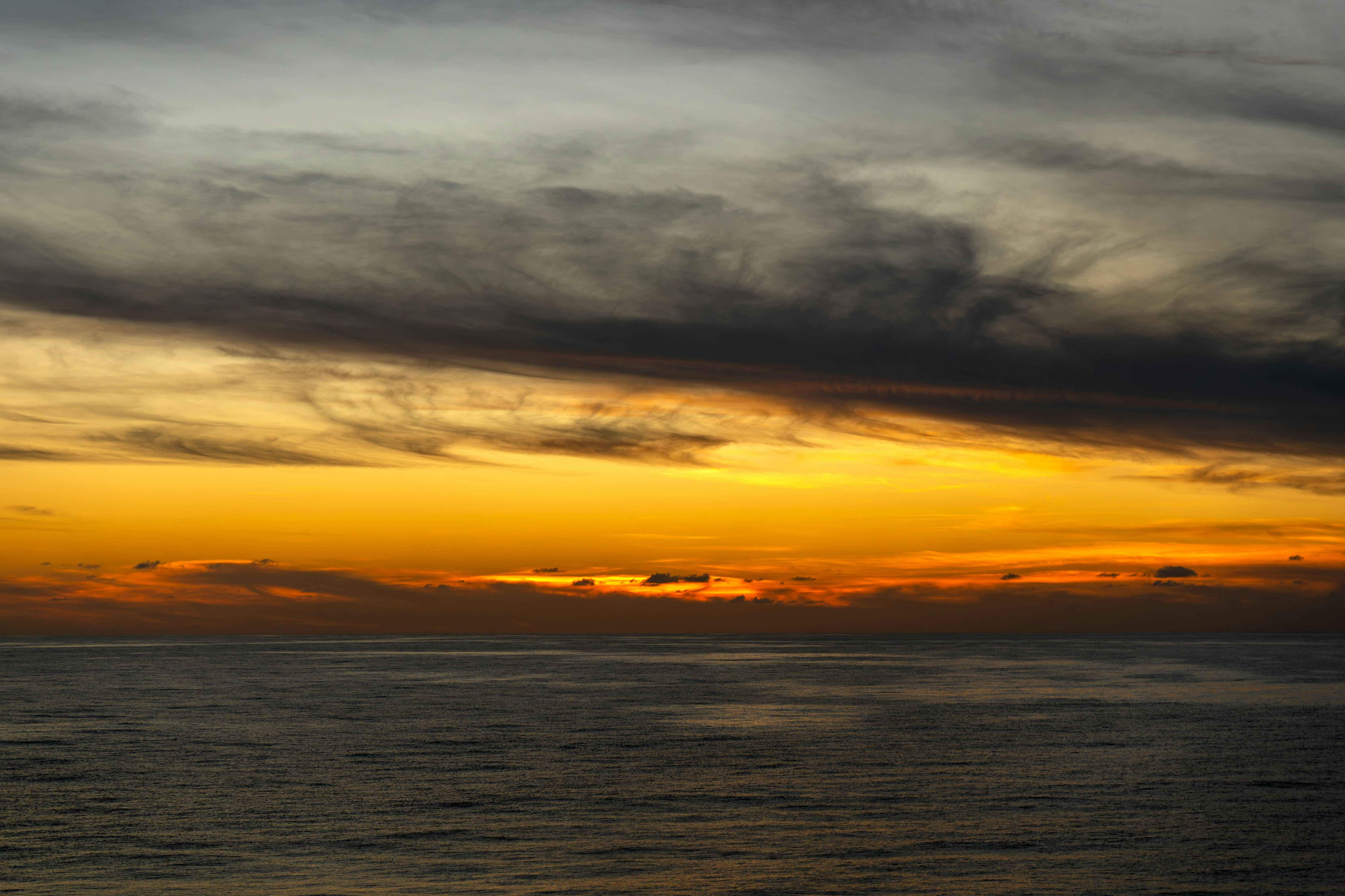 Horizontal Horizon Fire: A Quiet Sunset Over Calm Seas