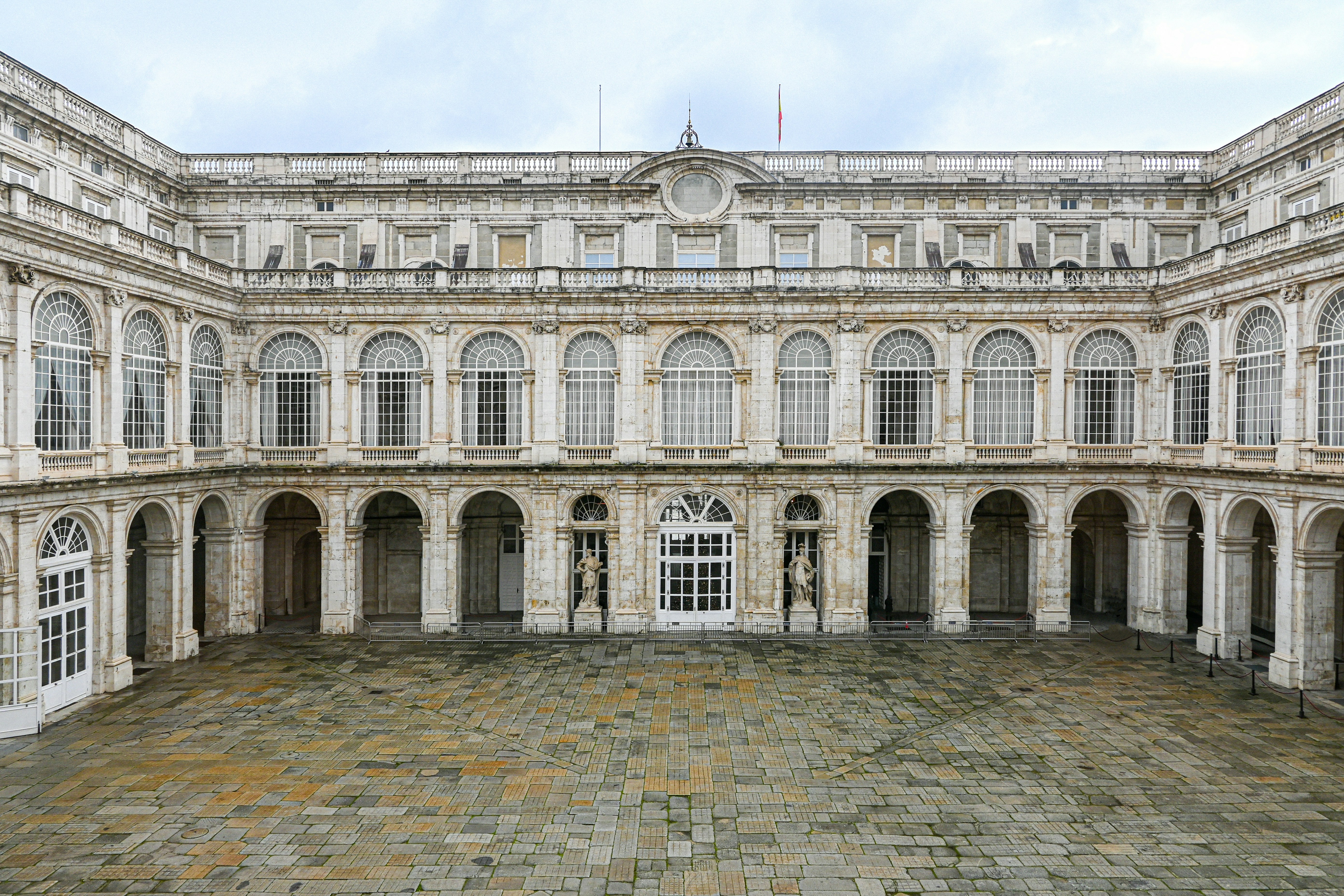 Symmetry and Stone: Courtyard Arches Under a Pale Sky