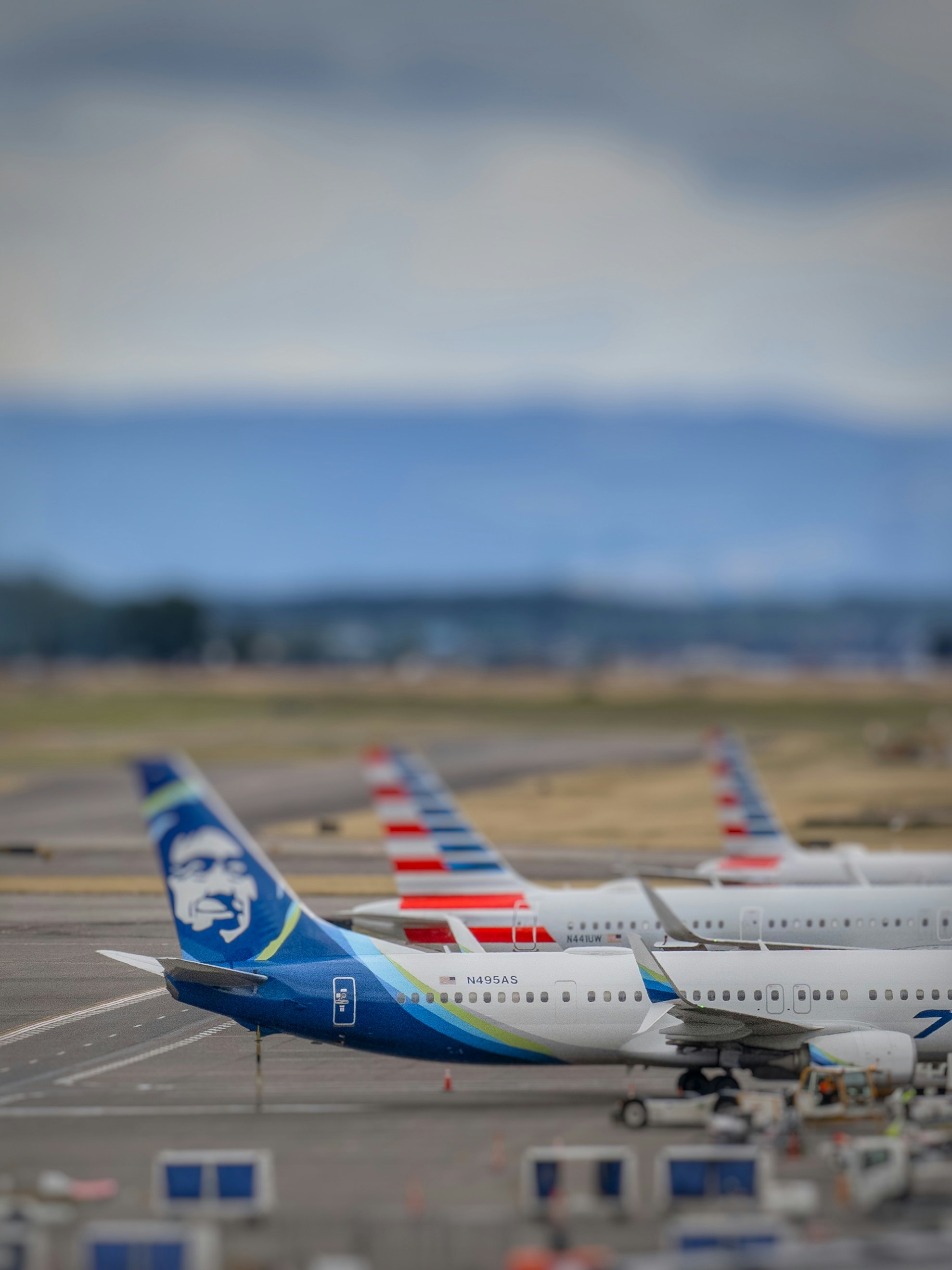 Blue Alaska tail at the gate: a row of American jets ready for departure