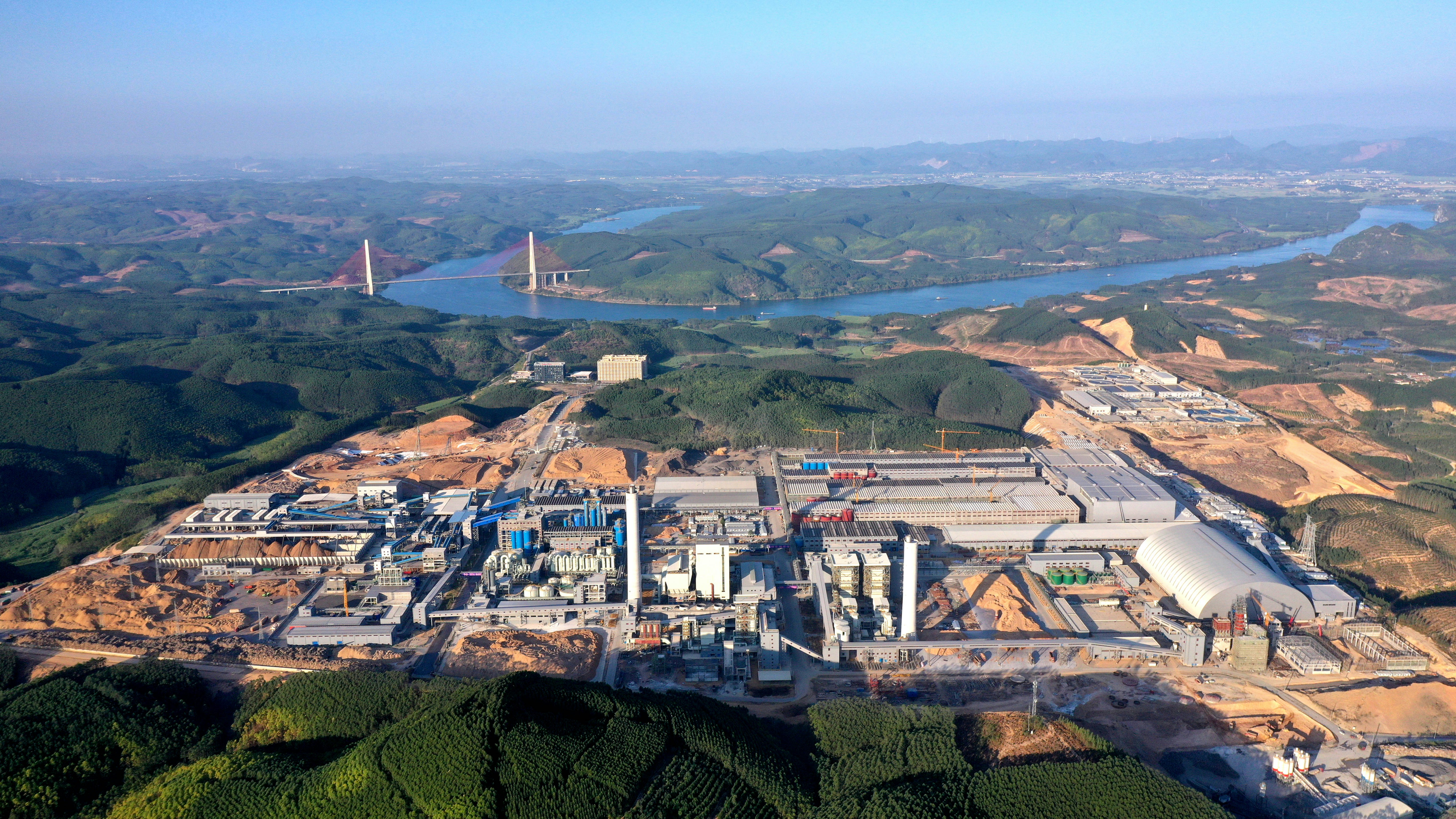 Overhead Vista: A Patchwork of Industrial Complexes Meets Verdant Hills