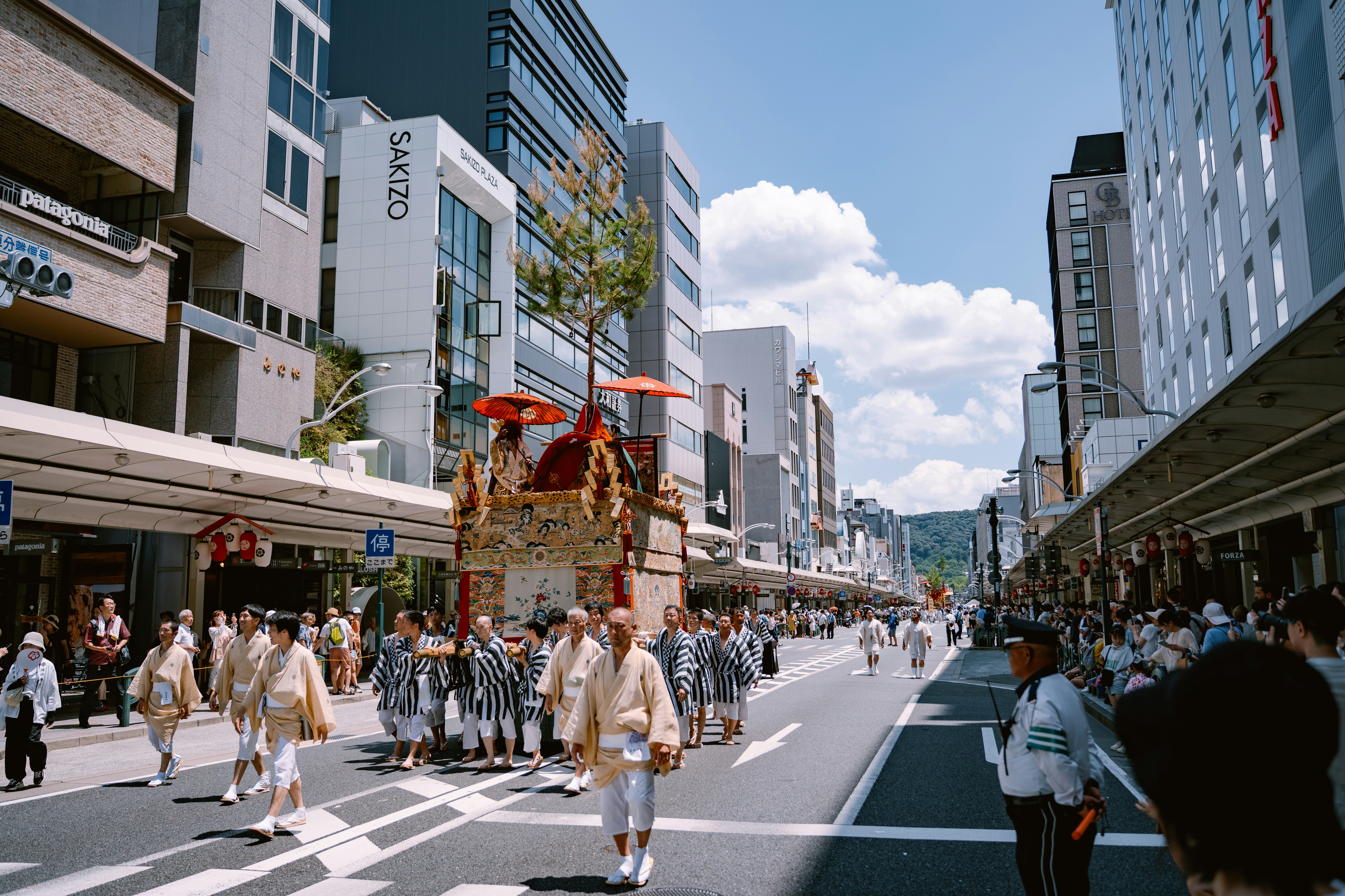 Festival Street: a ceremonial float winds through a sunlit urban parade