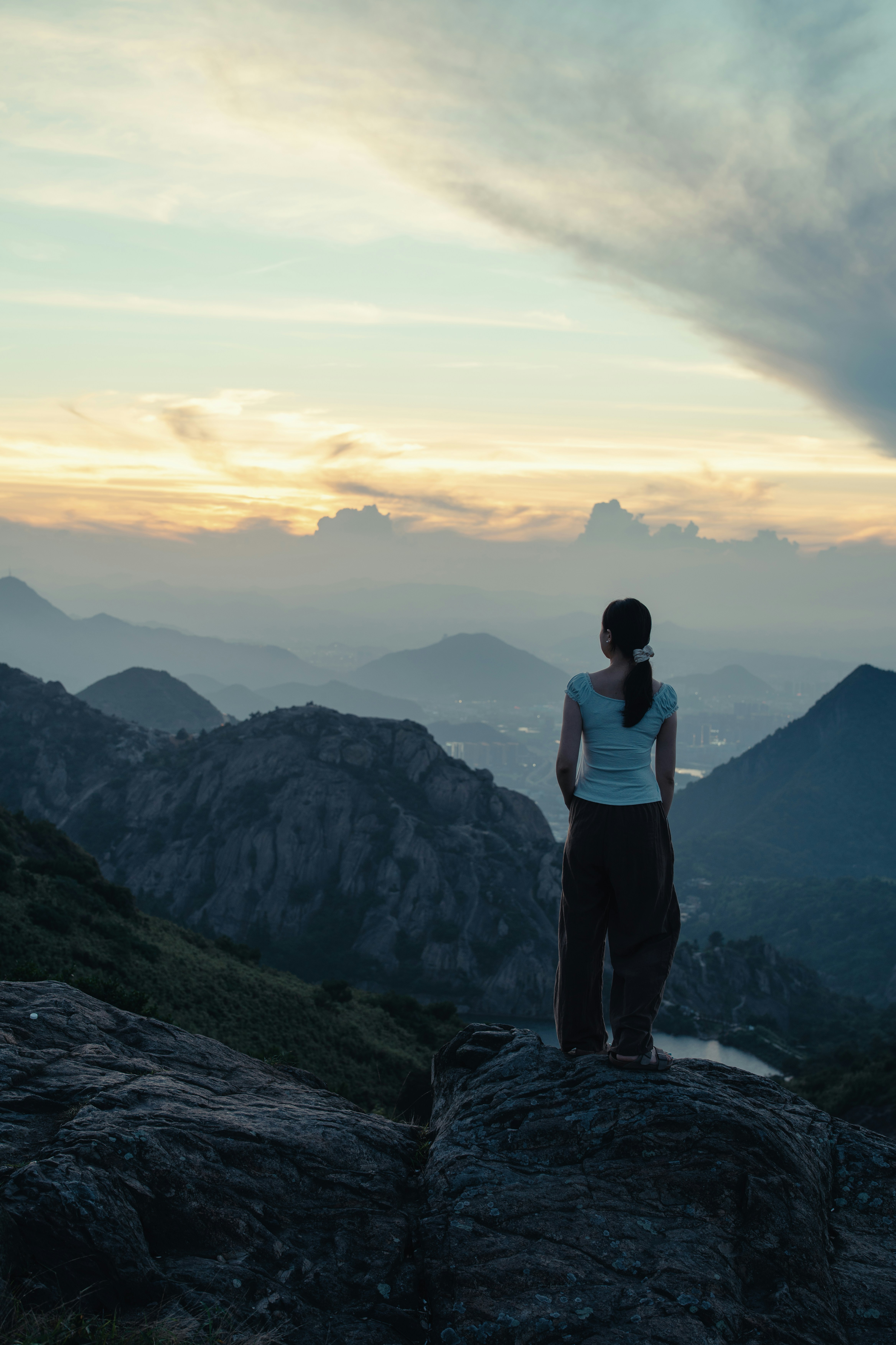 Stargazer on the Edge: Woman in Blue at Dusk Over Mountain Pews