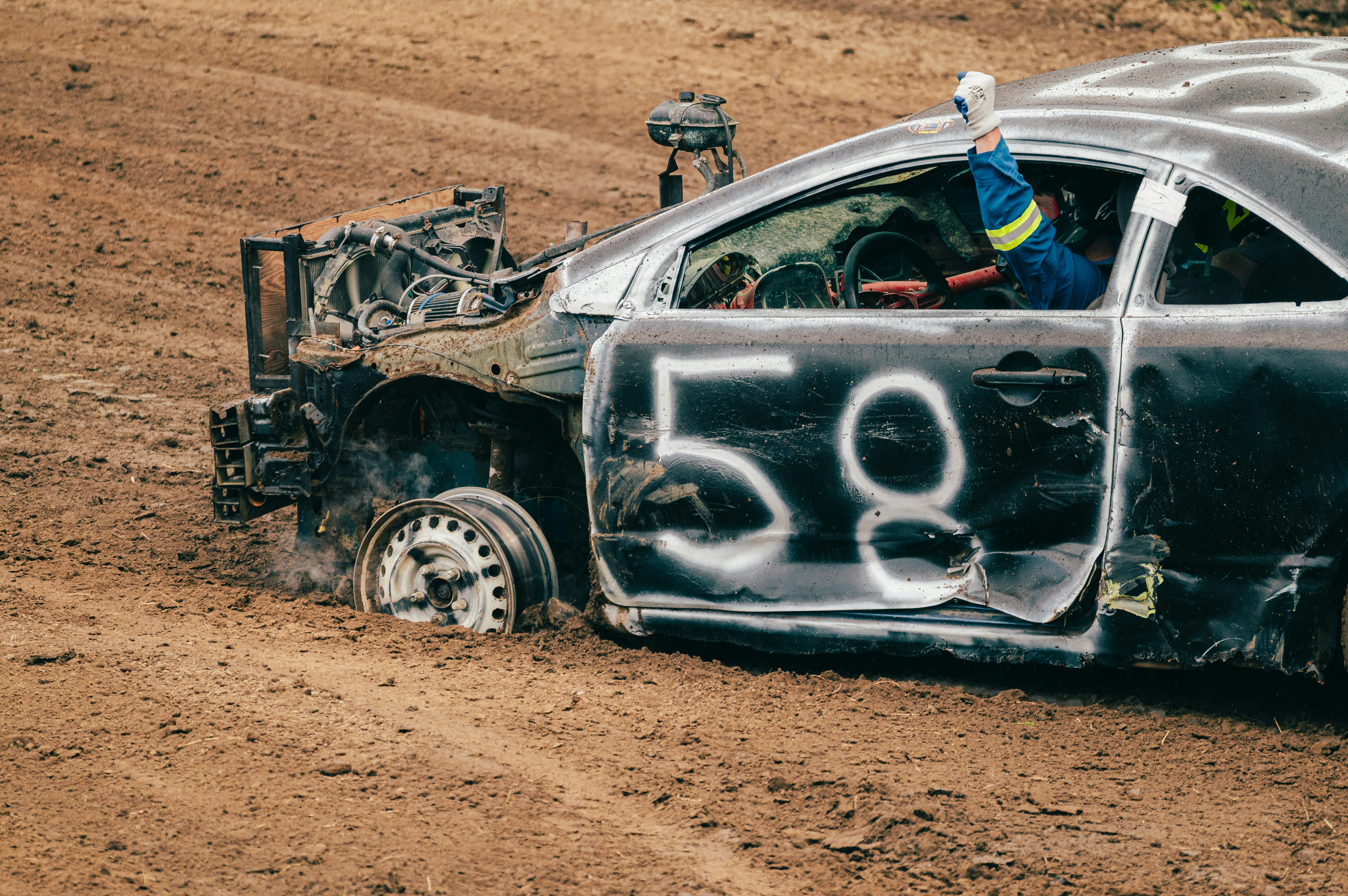 58 on the Track: Charred Car Half-Buried in Red Dirt