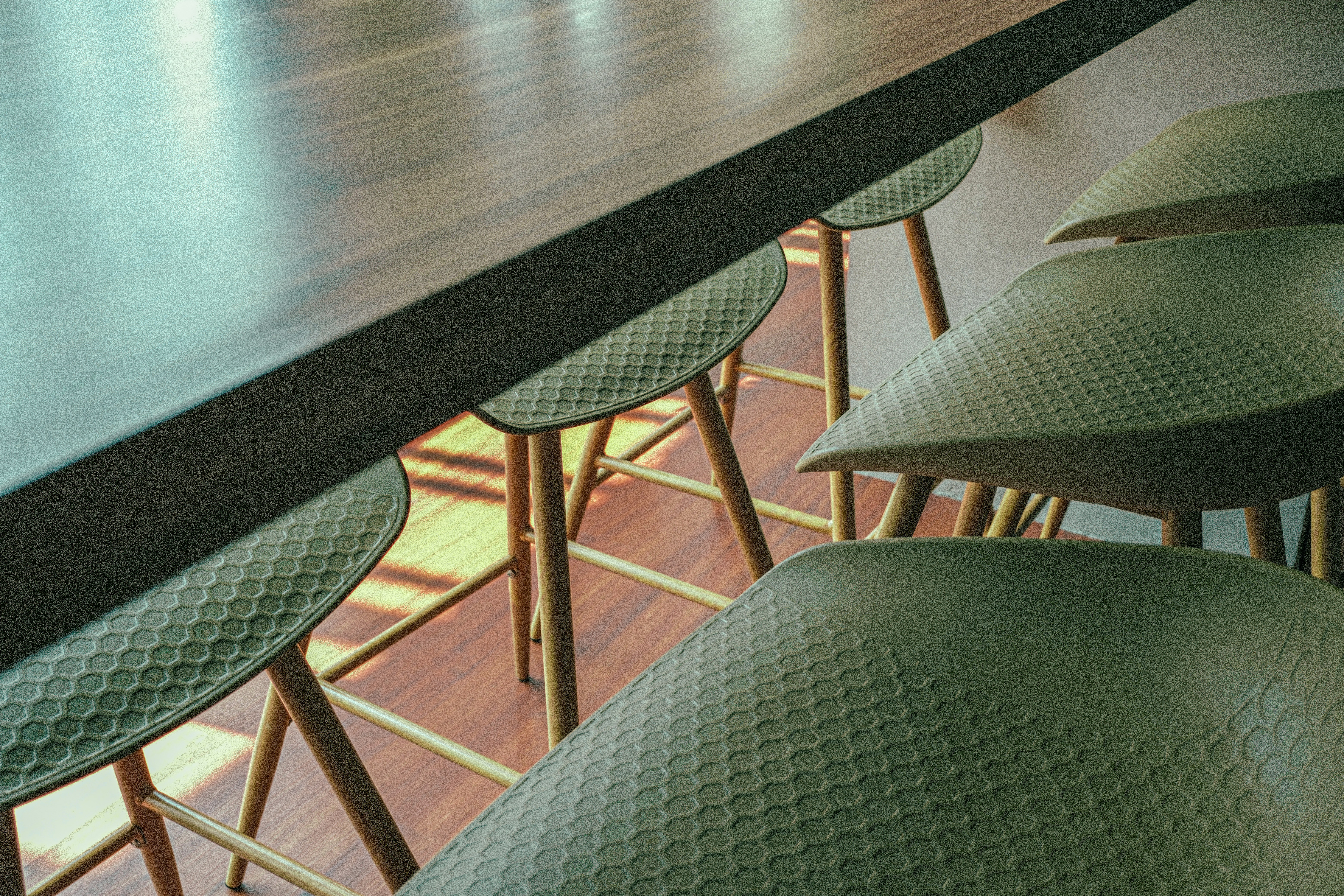 Cafe Seating Under a Walnut Table: Geometric Light and Leg Patterns