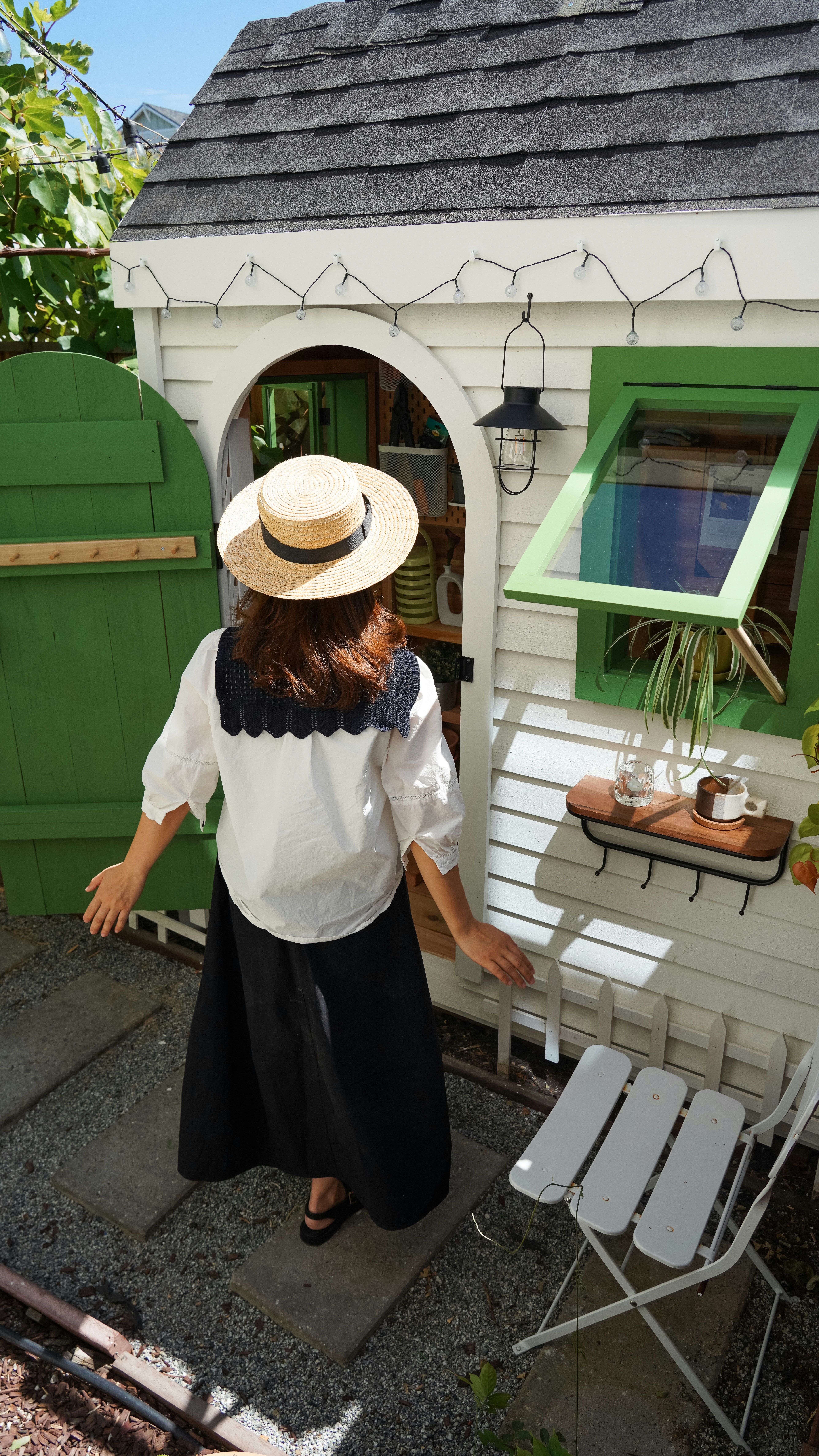 Sunlit Cottage Corner: A Woman in a Straw Hat at the Green Door