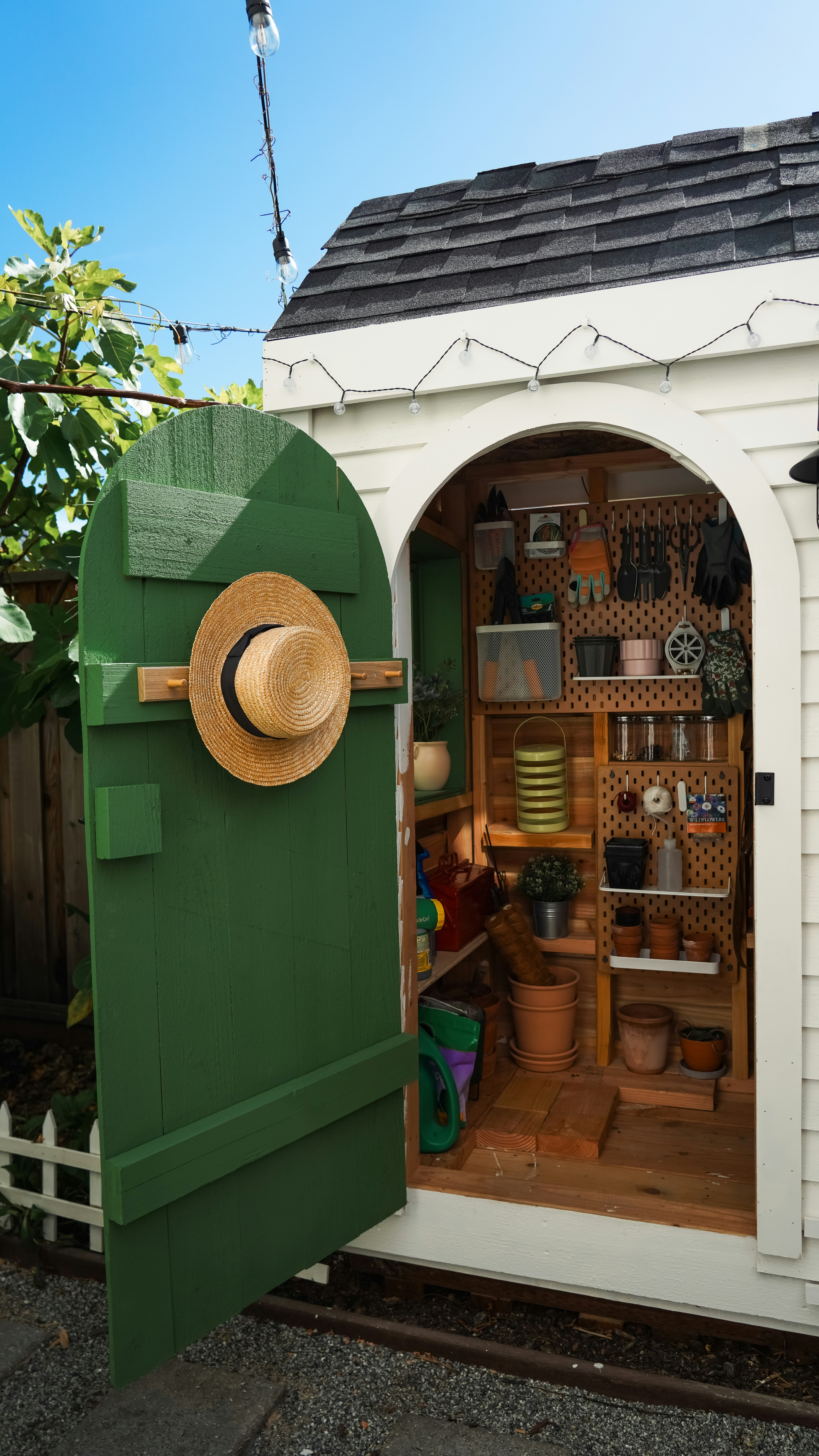 Green Gate Opens to a Rustic Garden Shed Filled with Tools