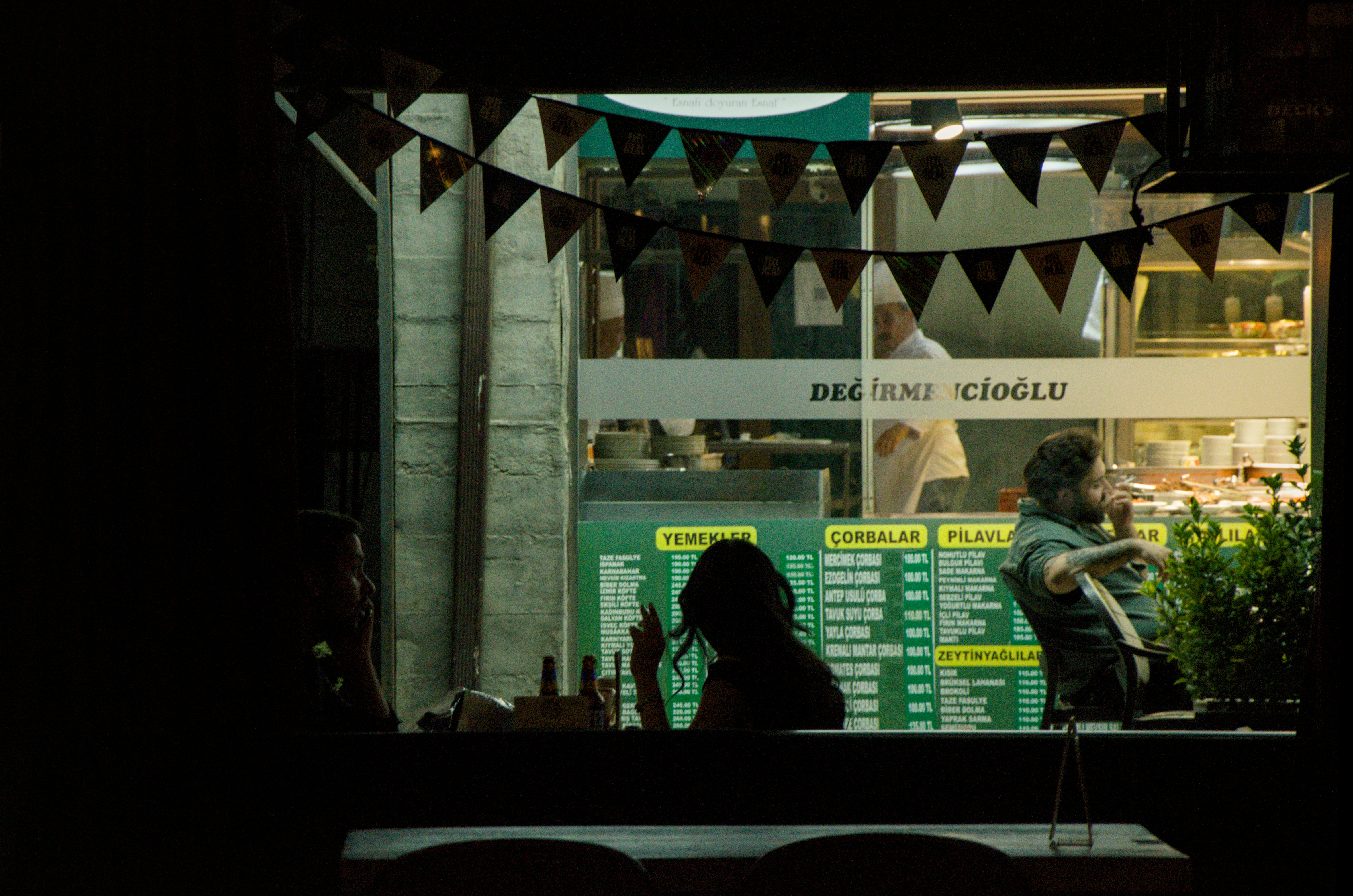 Midnight Market Window: Silent Conversations Under Festive Banners