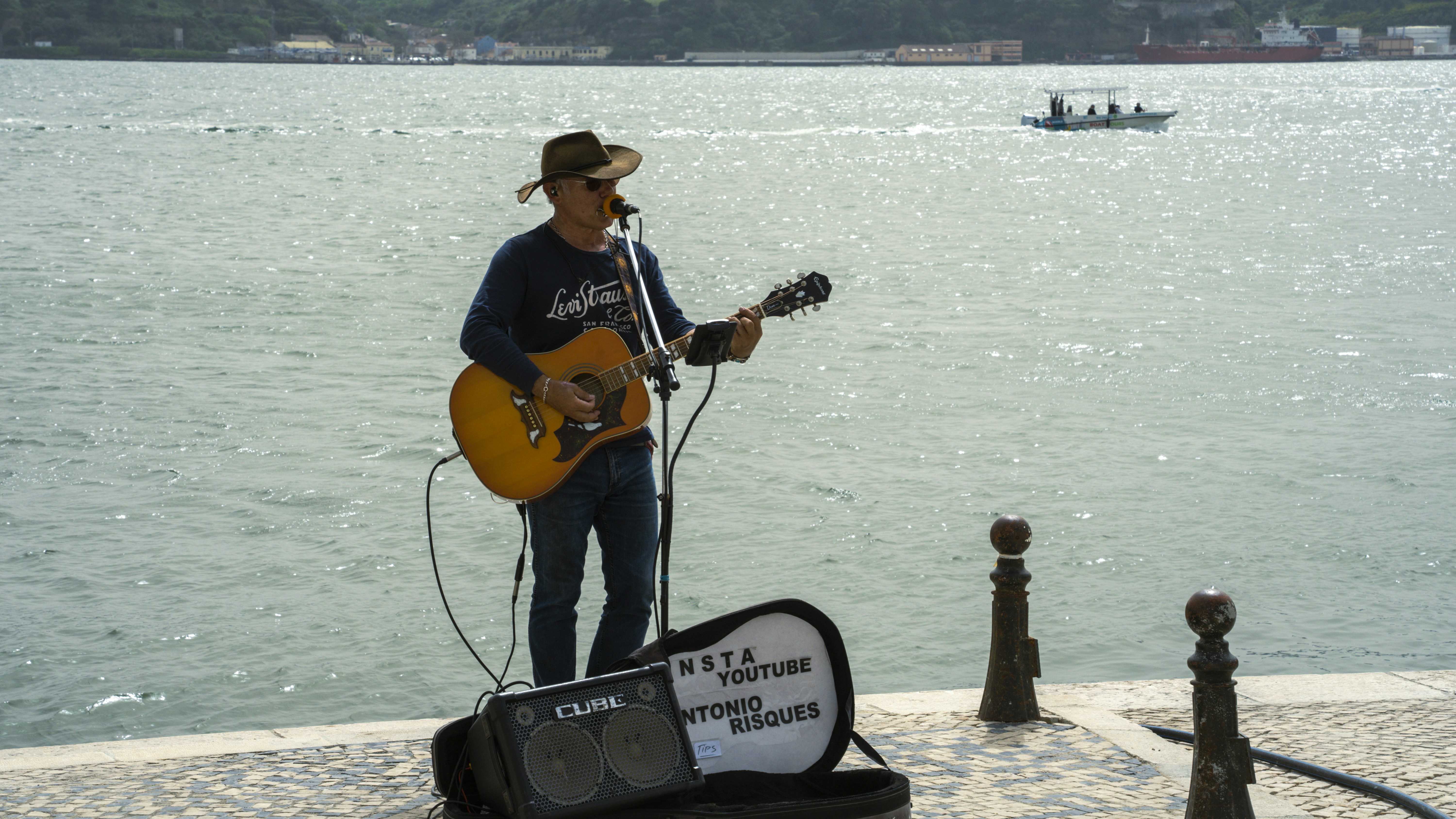 Guitarist by the Water: Street Serenade on a Seaside Promenade