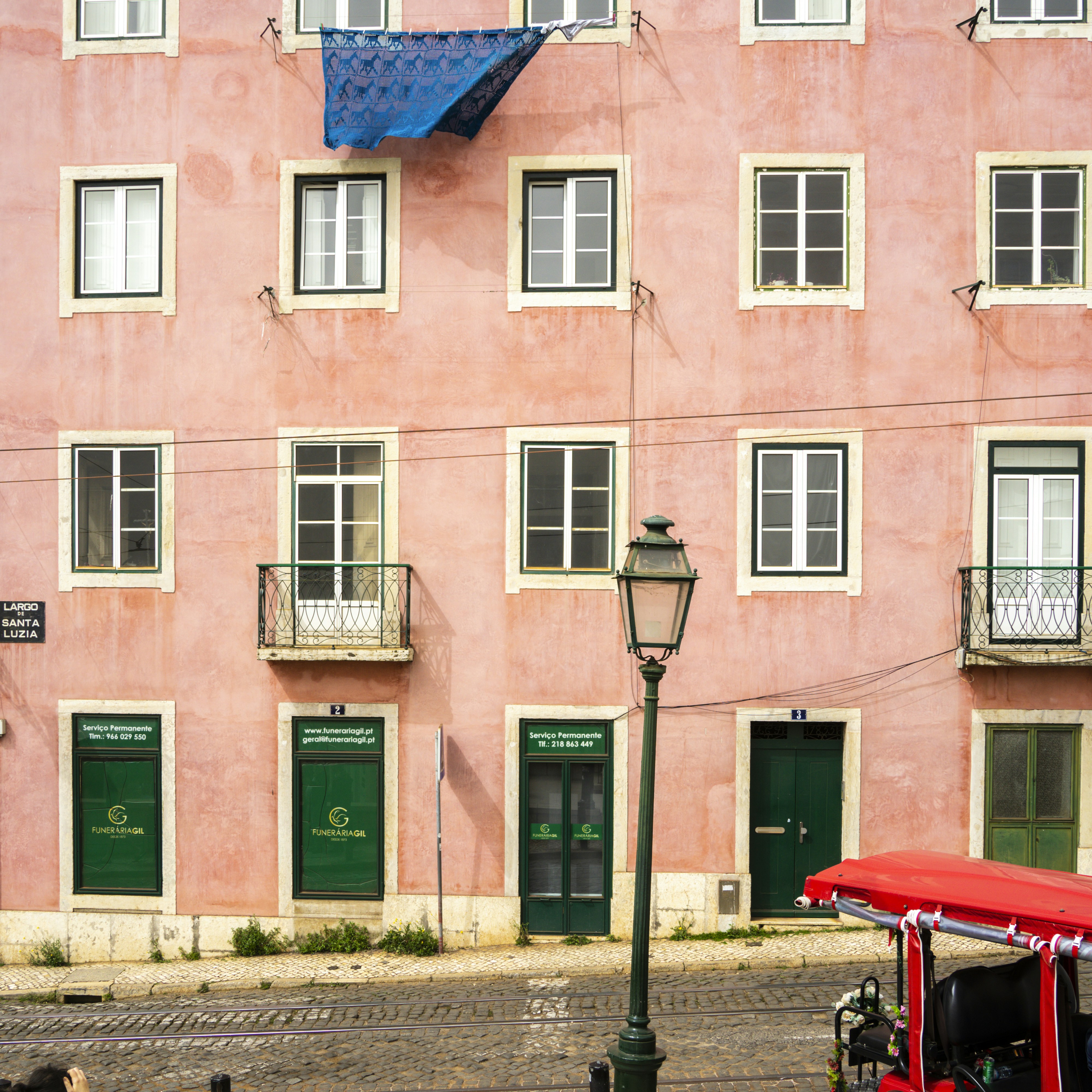 Peach Facade and Street Lanterns under a Blue Canopy