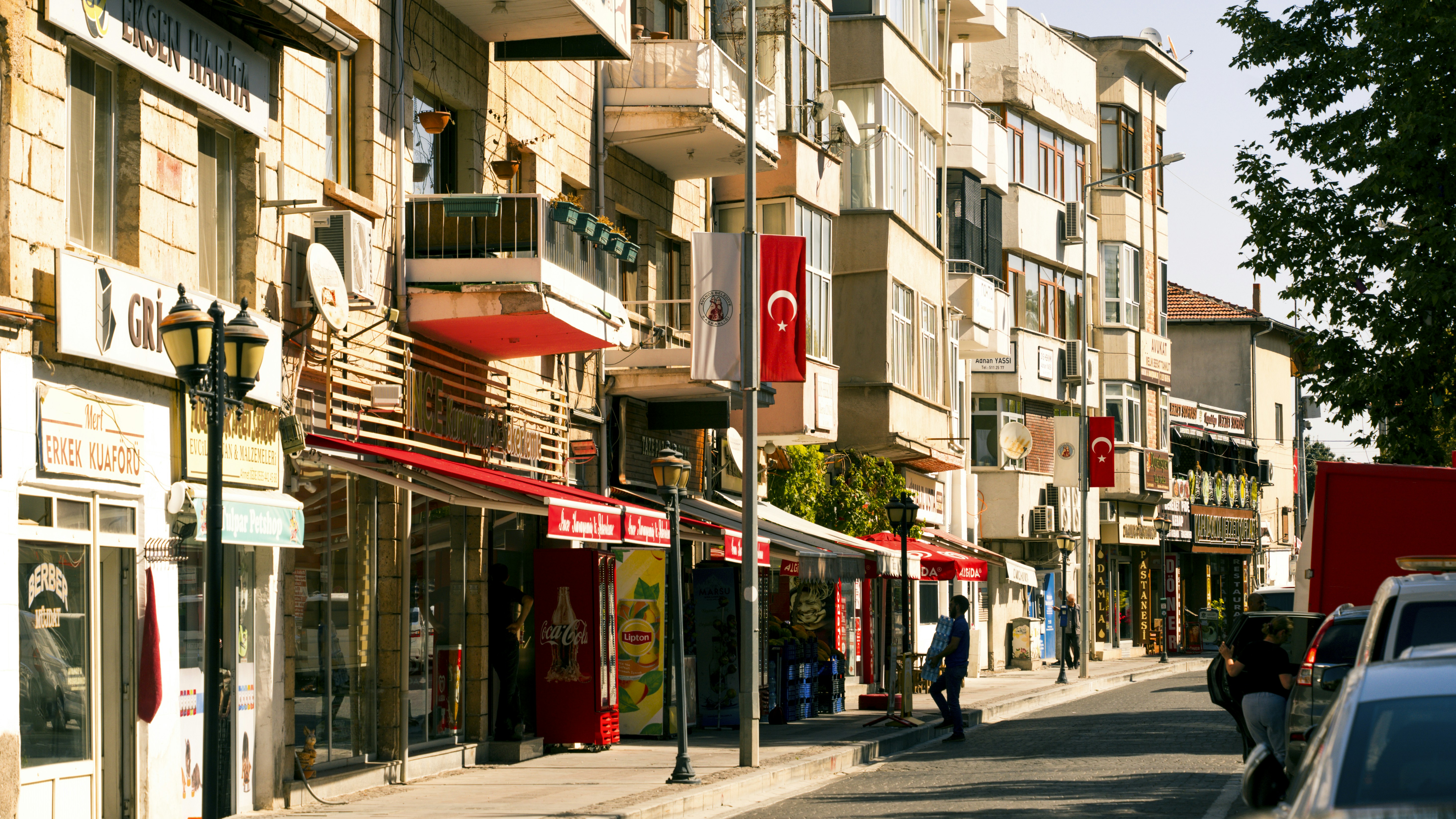 Turkish Street Corner: Sunlit Shops and Red Awnings