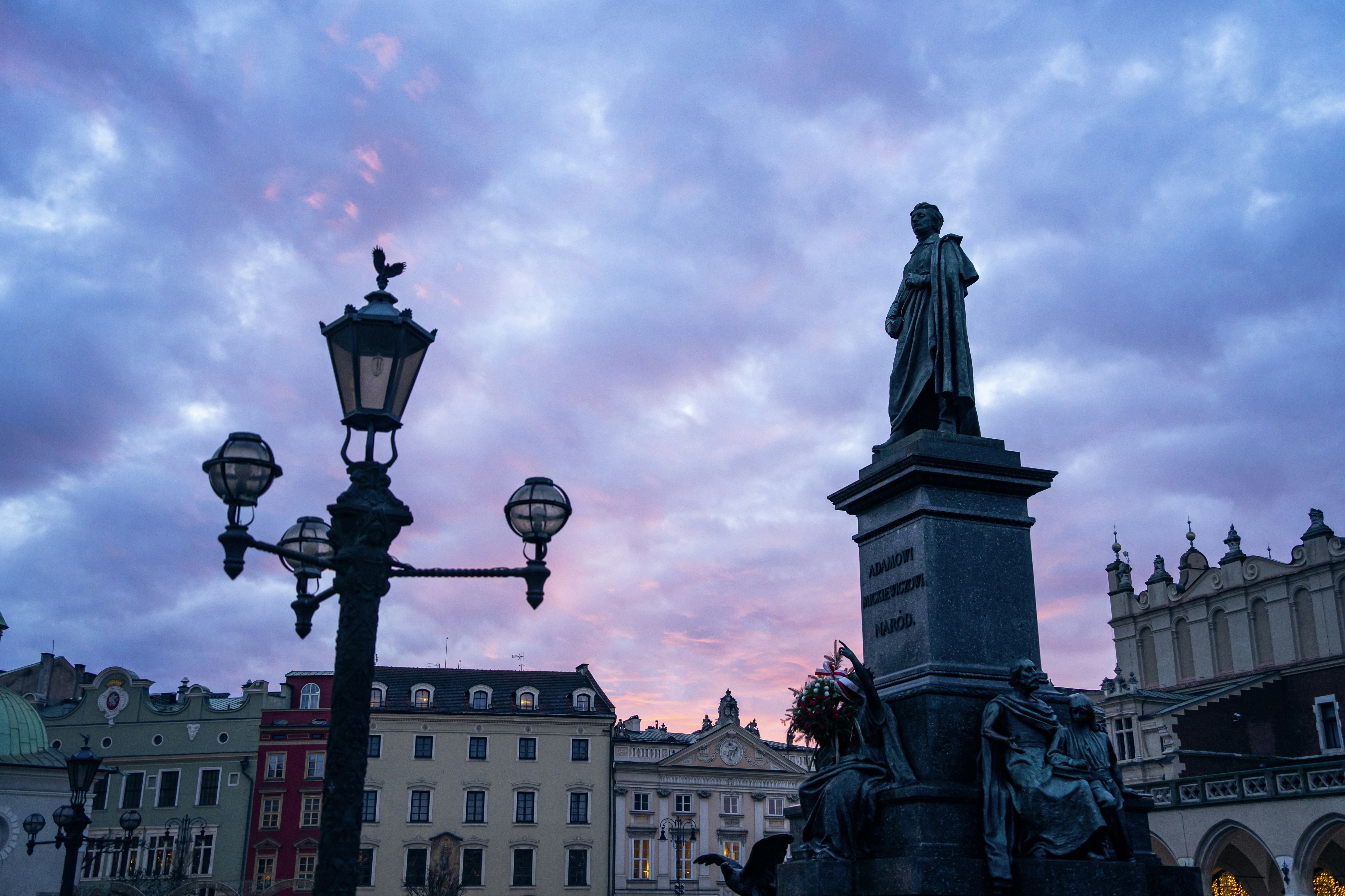 Dusk Over the Square: Statue and Lanterns Against a colored Sky