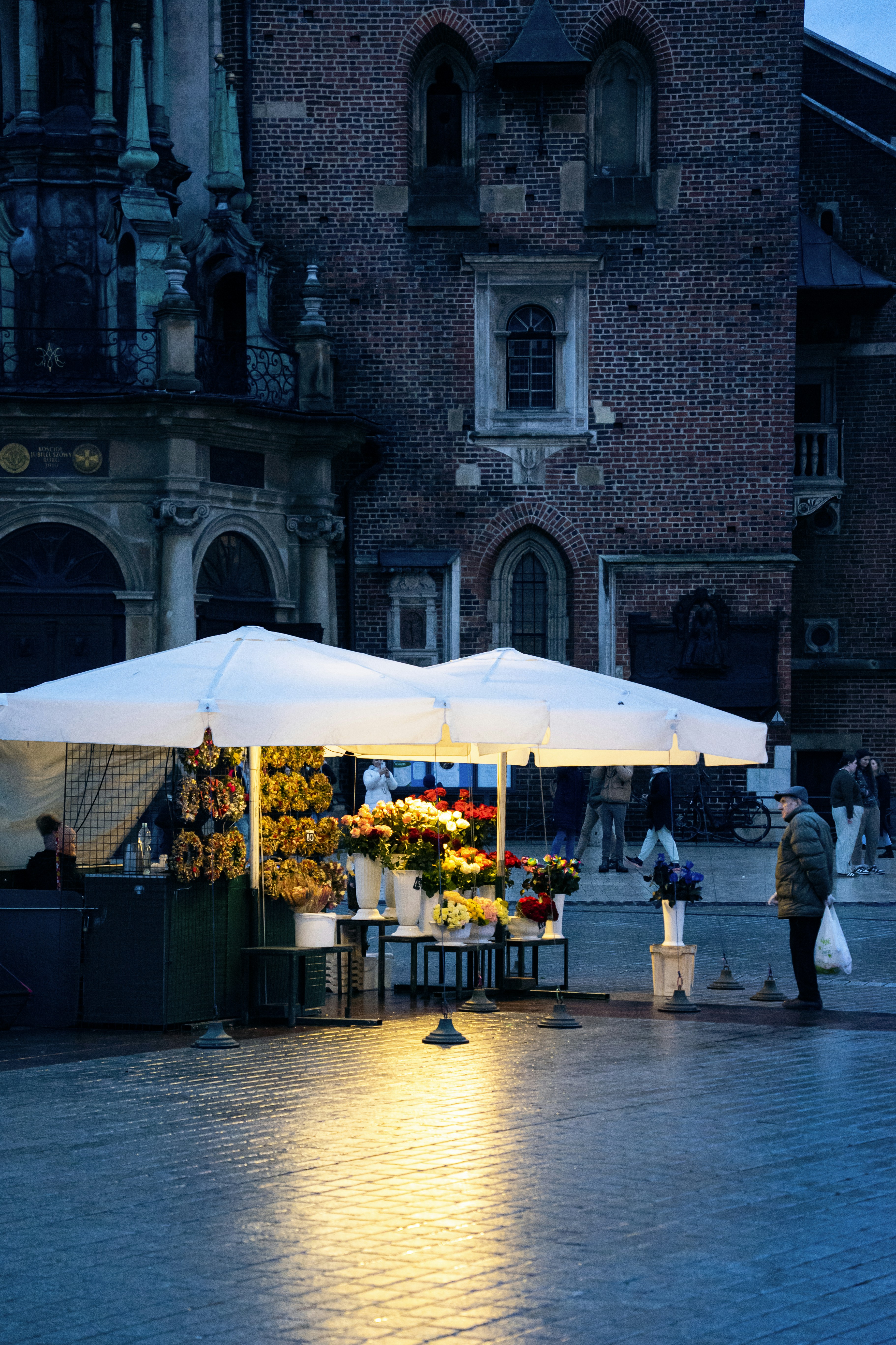 Market Flowers Under Evening Umbrellas by the Historic Brick Facade