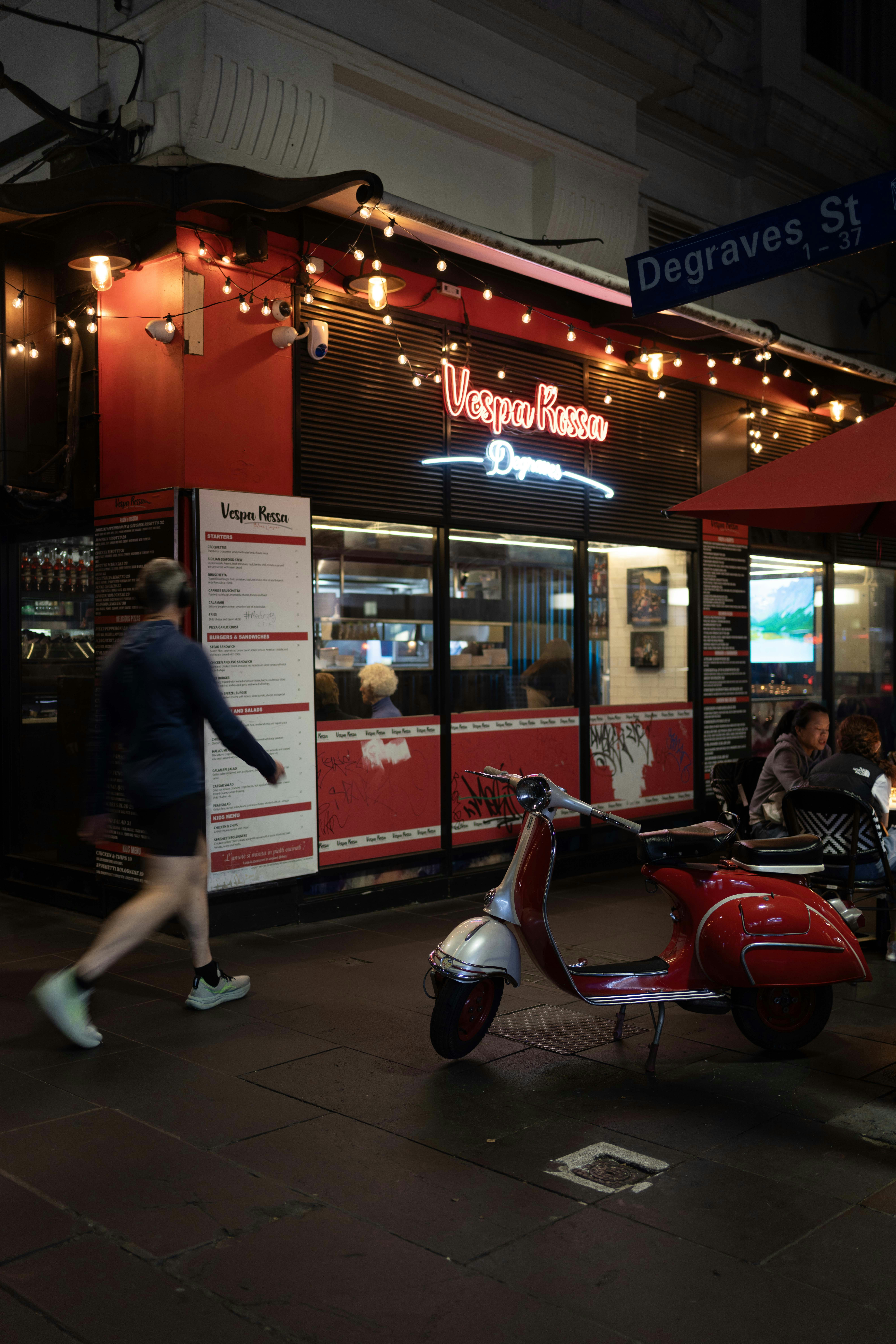 Red Vespa Rendezvous at a Neon-Lit Corner