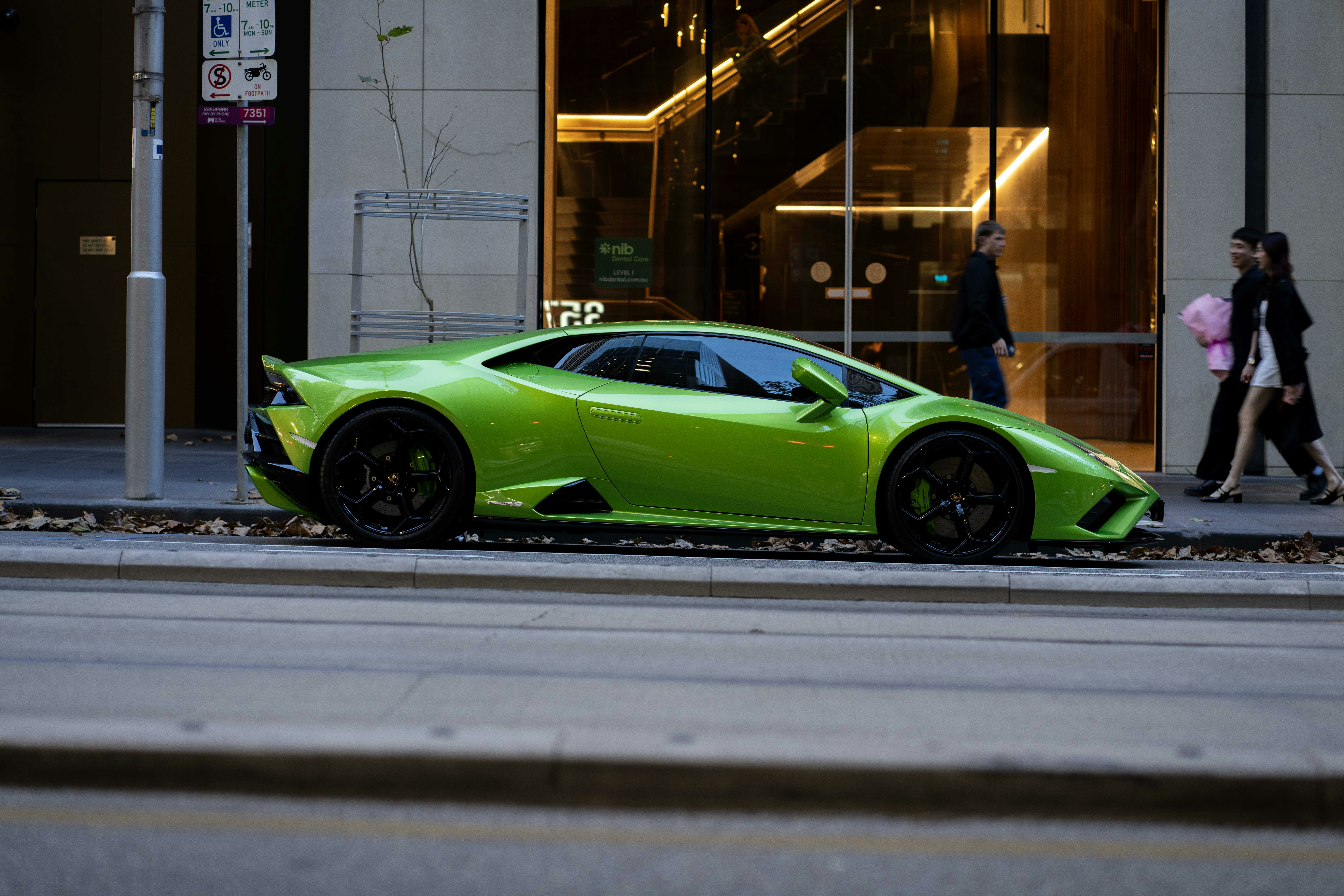 Lime green hypercar anchors the urban street at golden hour