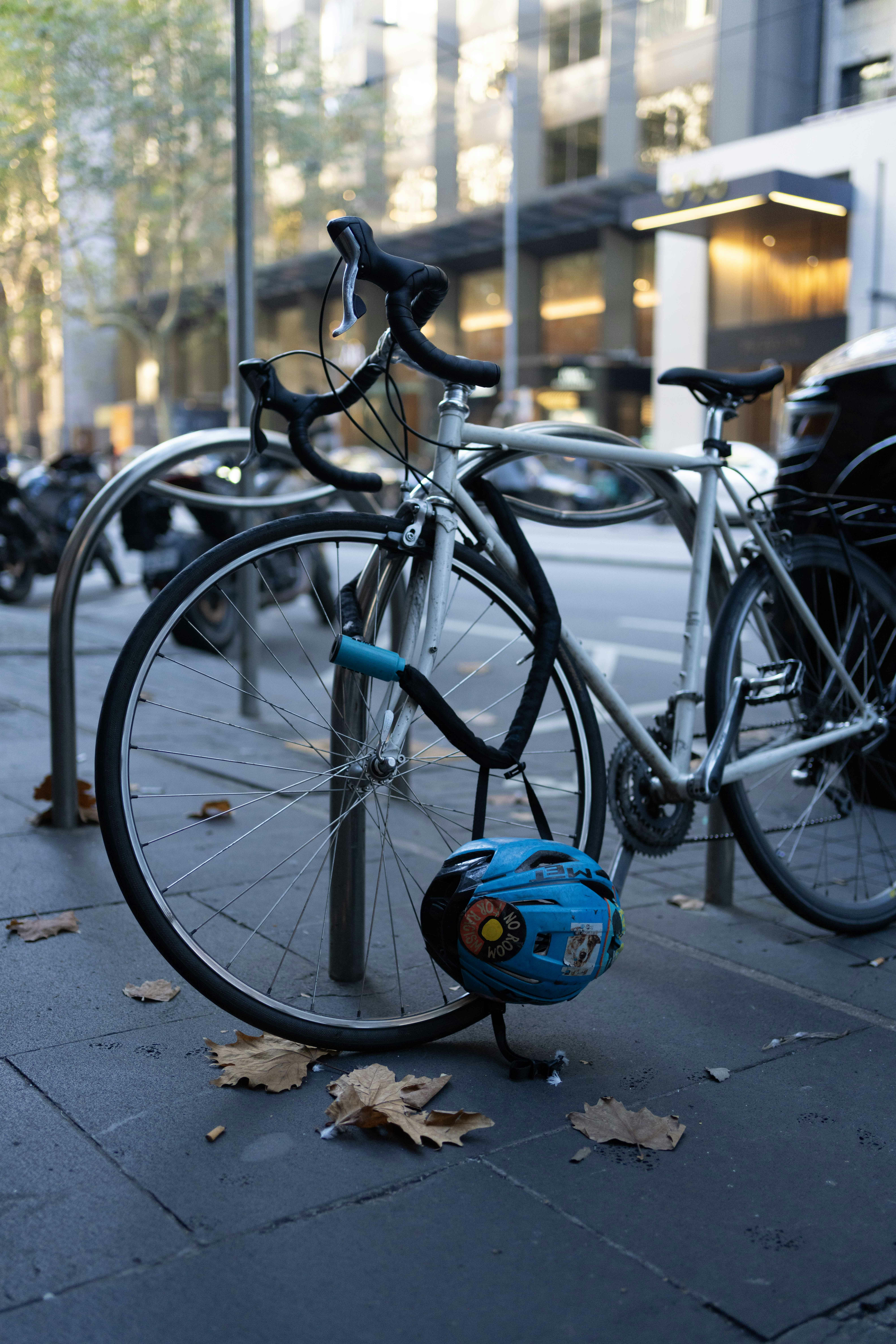 Urban Bike Rack Symphony: A Helmet Resting by the Chain