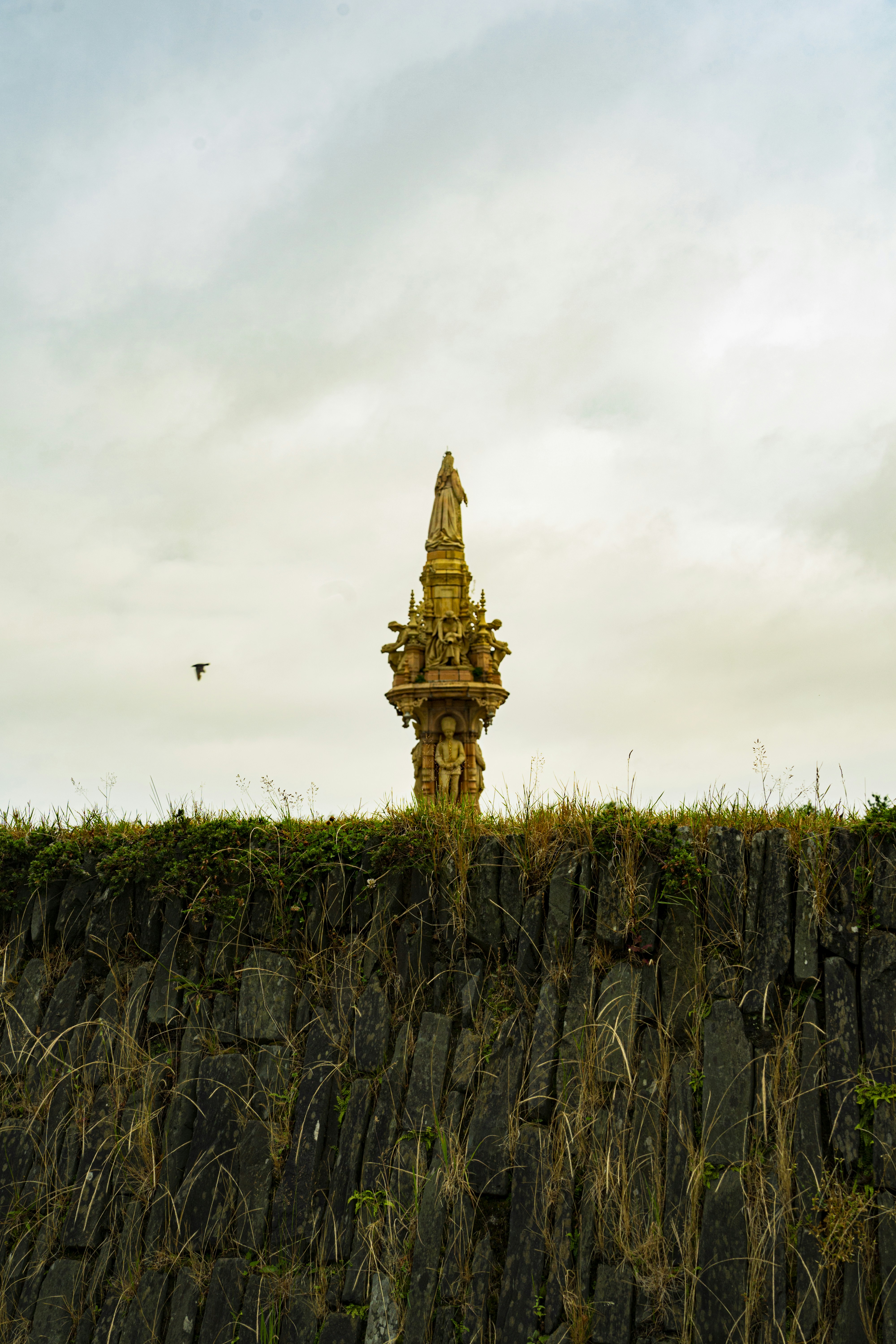 Stone Monument Reaching Above the Hedge
