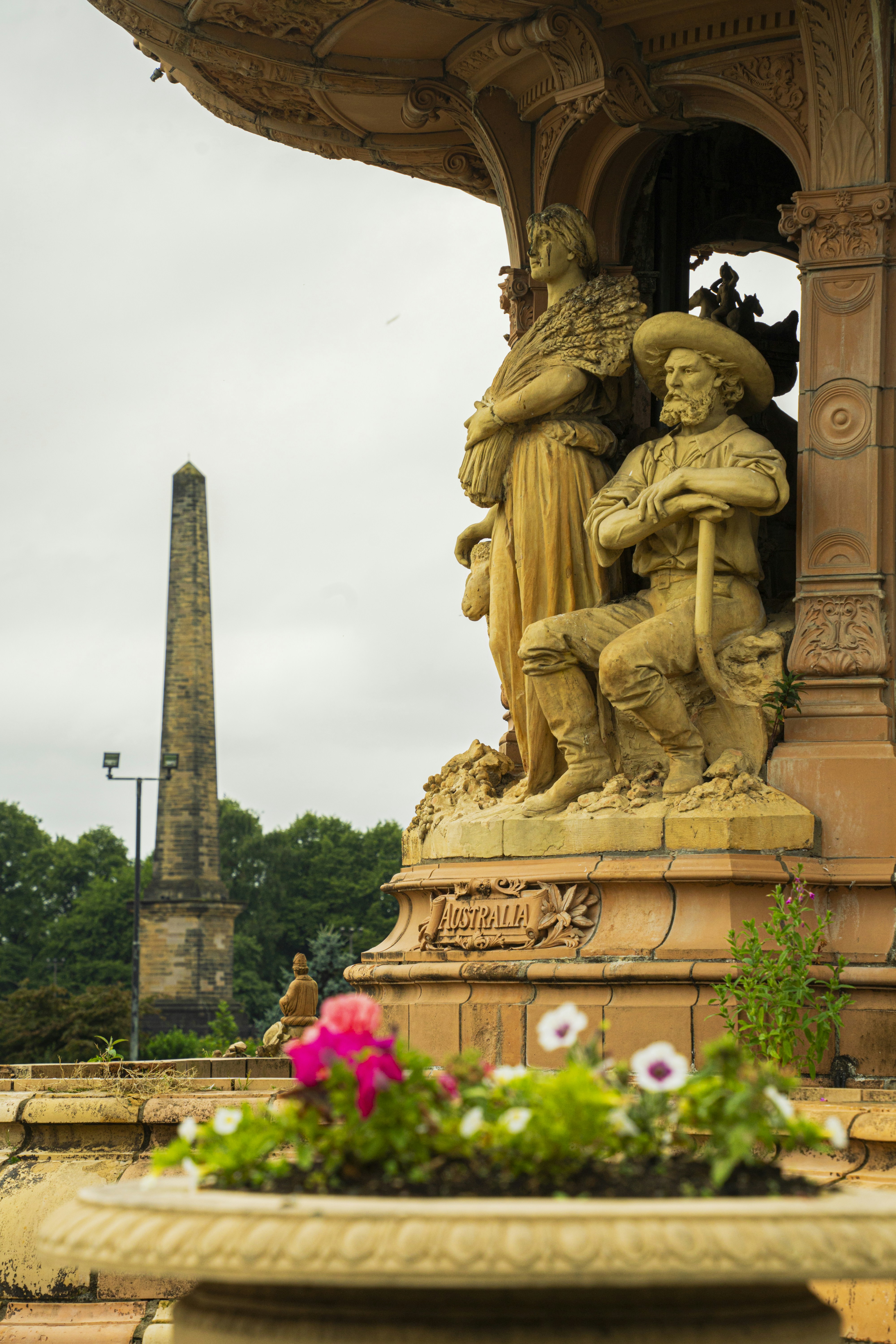 Statues at the Pavilion: Weathered Grace Overlooking the Obelisk
