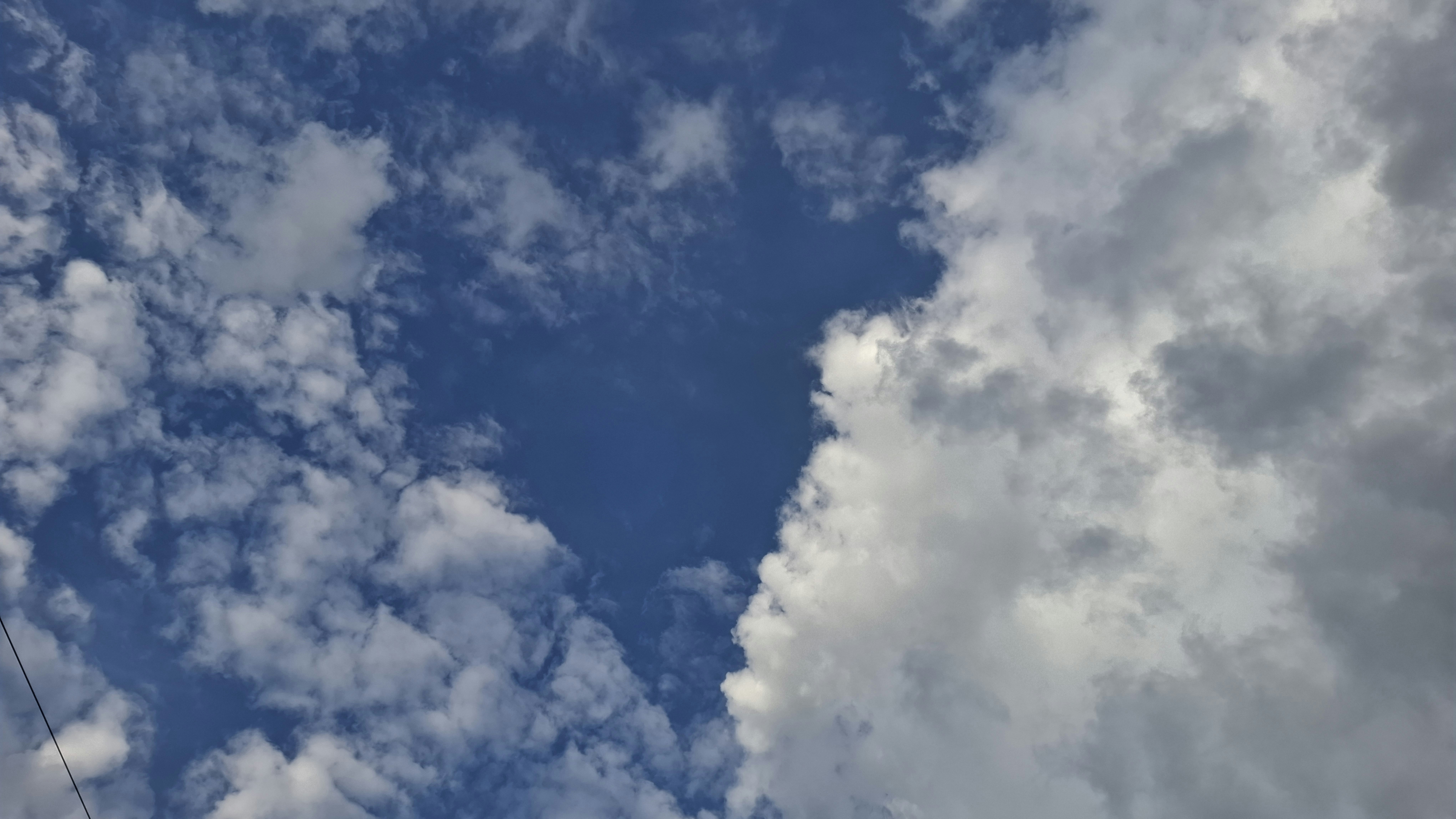 Bright sky with scattered cumulus clouds, conveying an expansive daytime atmosphere and open space.