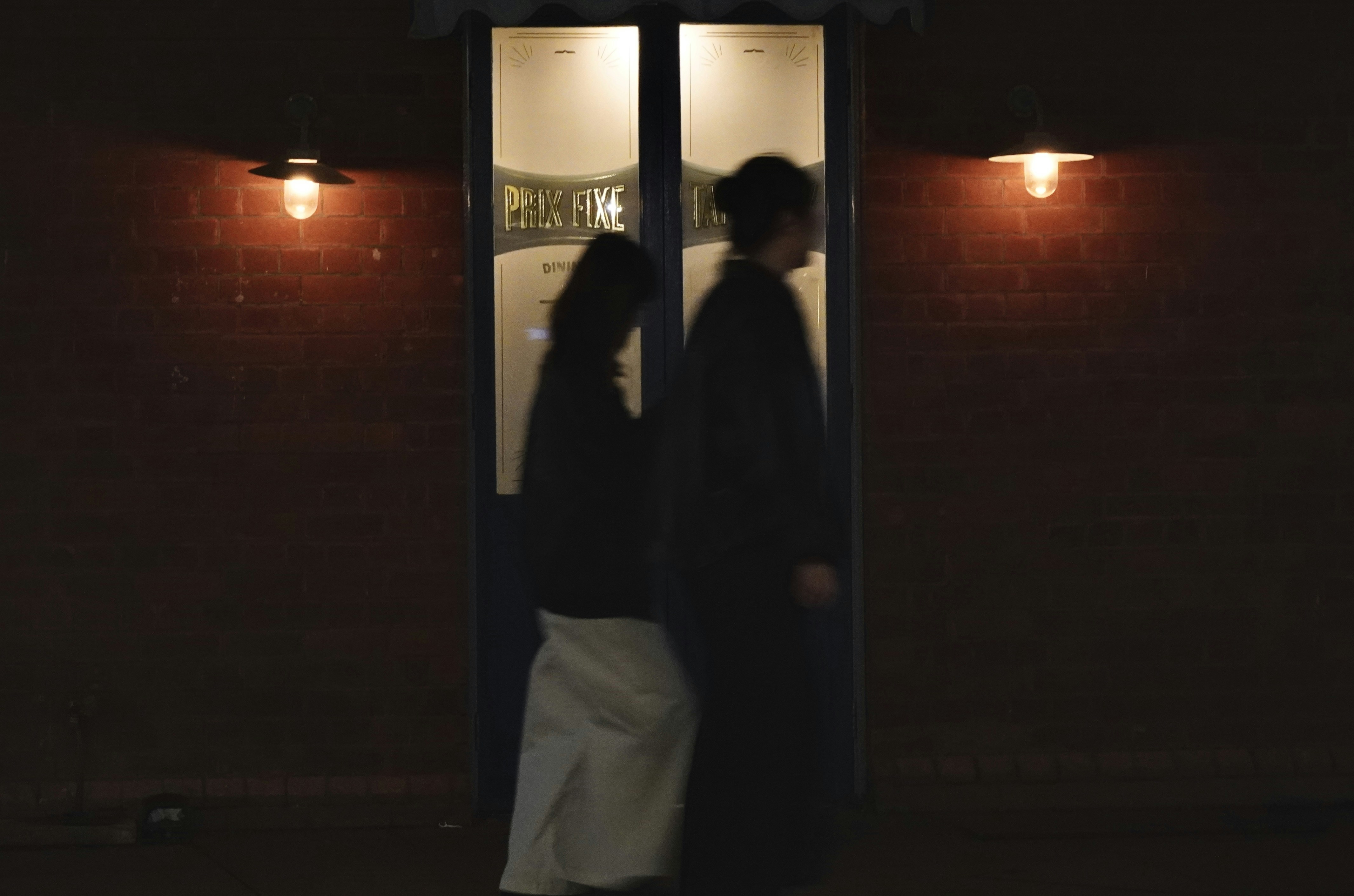 Whispers at the Doorway: Silhouettes in a Dim Corridor
