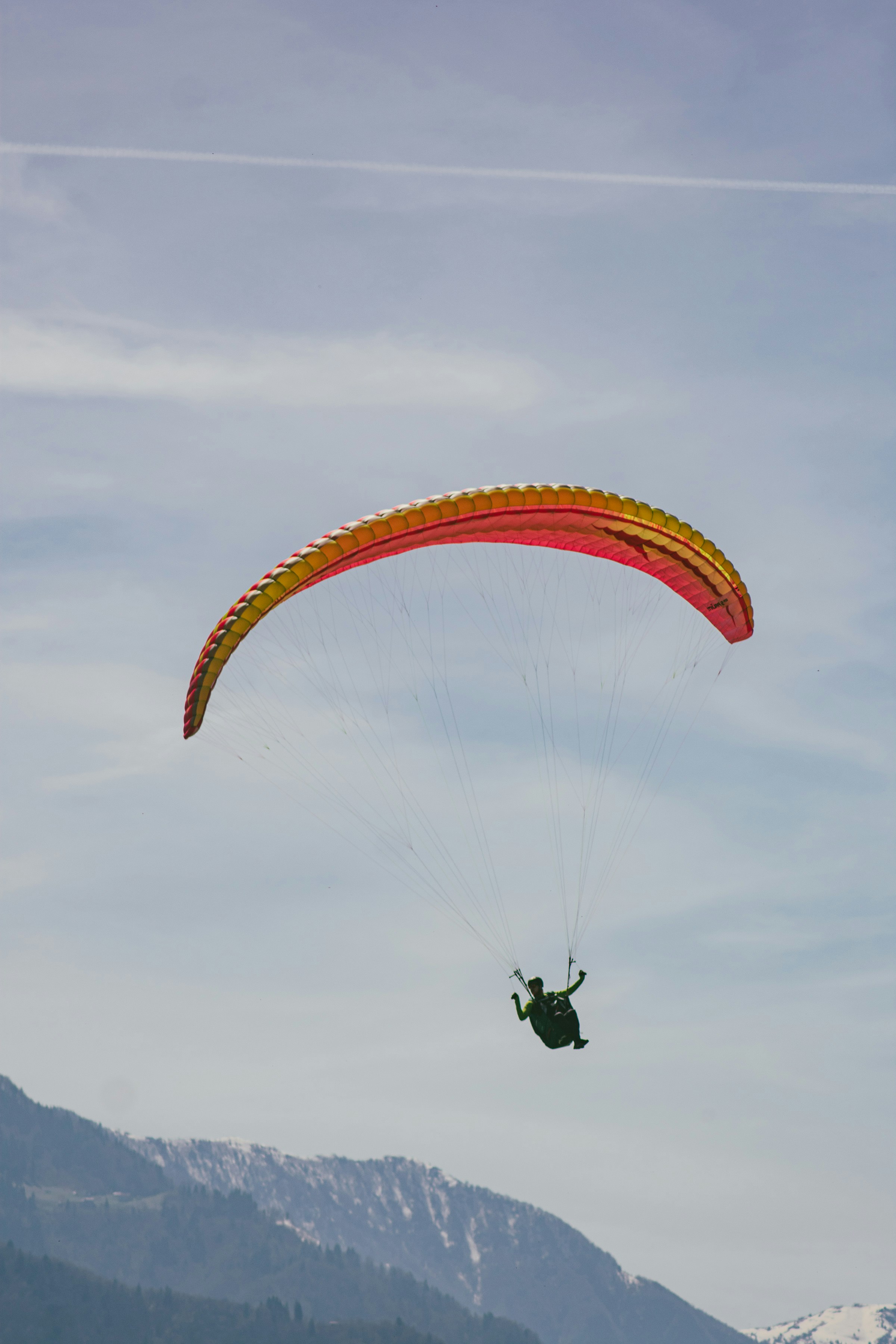 Soaring Rider: A Paraglider Against Alpine Light