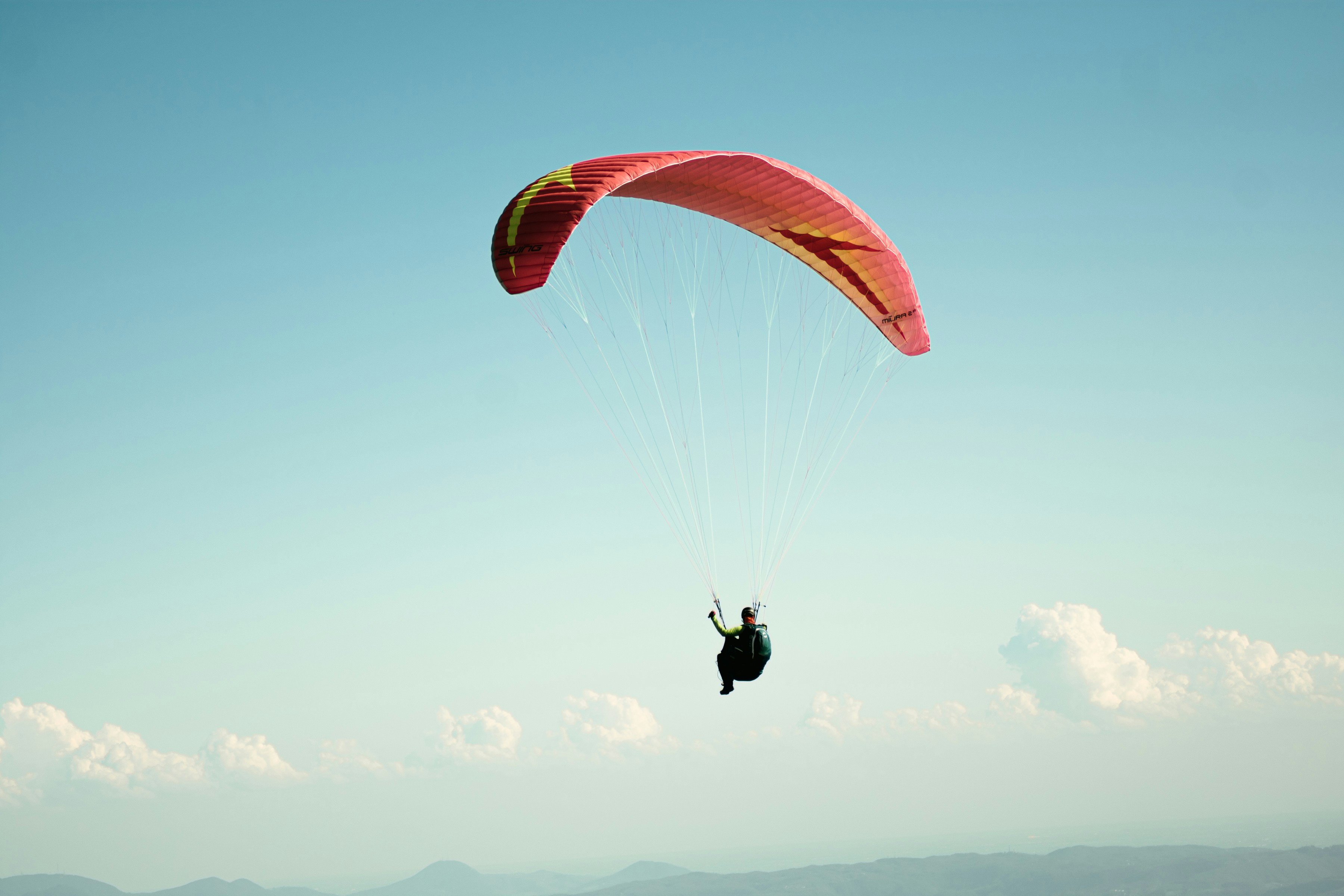 Suspended Pilot Against an Expansive Sky