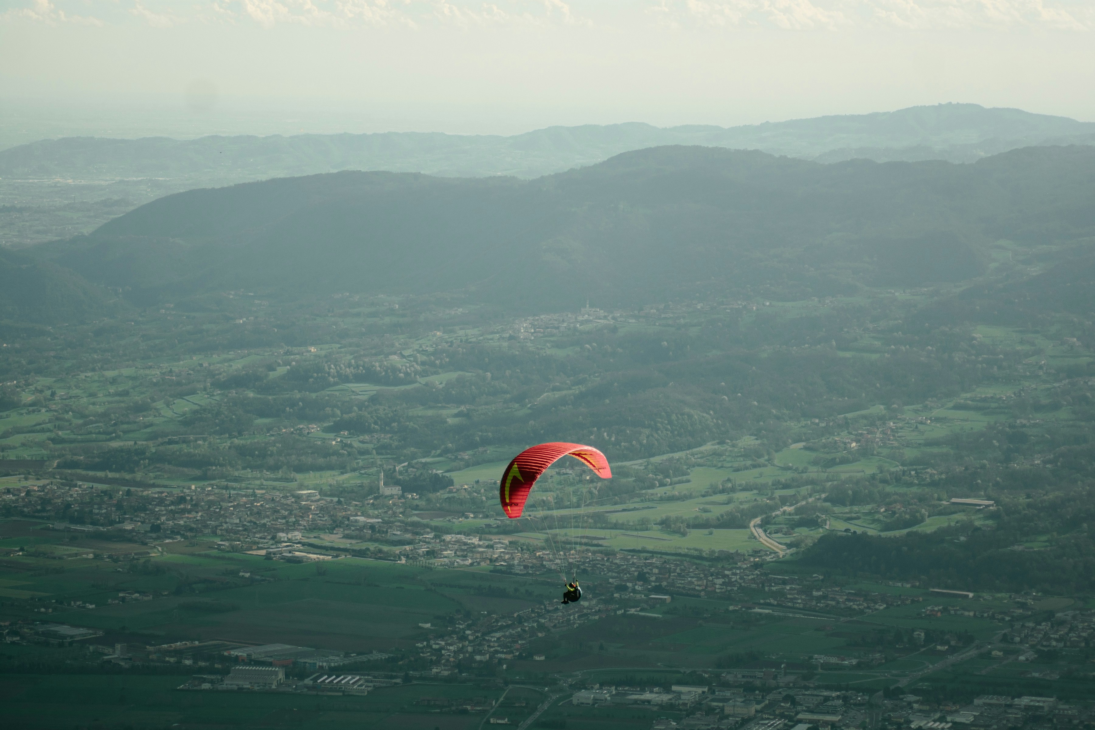 Red Paraglider Draped Over a Valley Vista