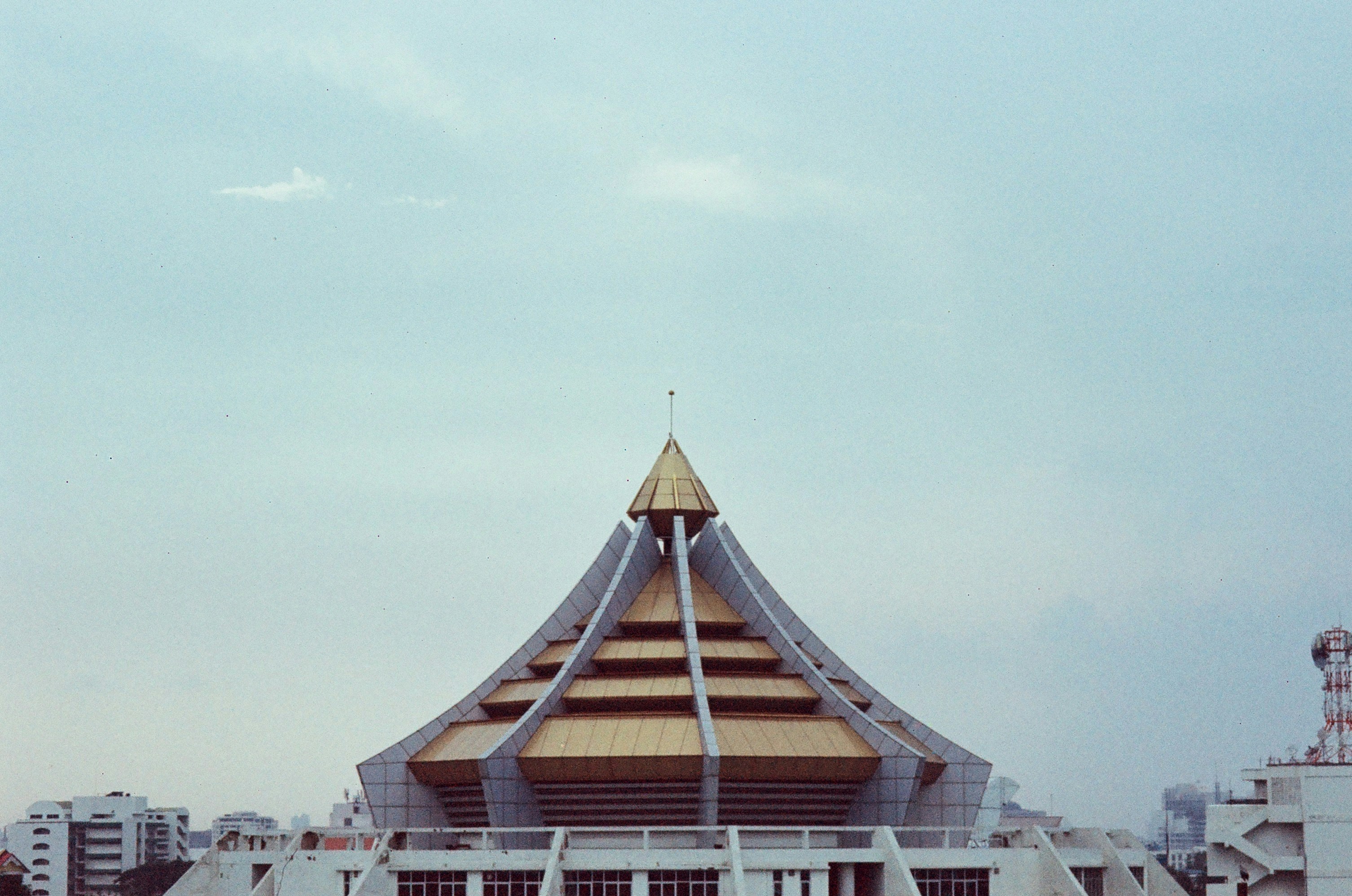 Distinctive building with a golden, tiered, conical roof.