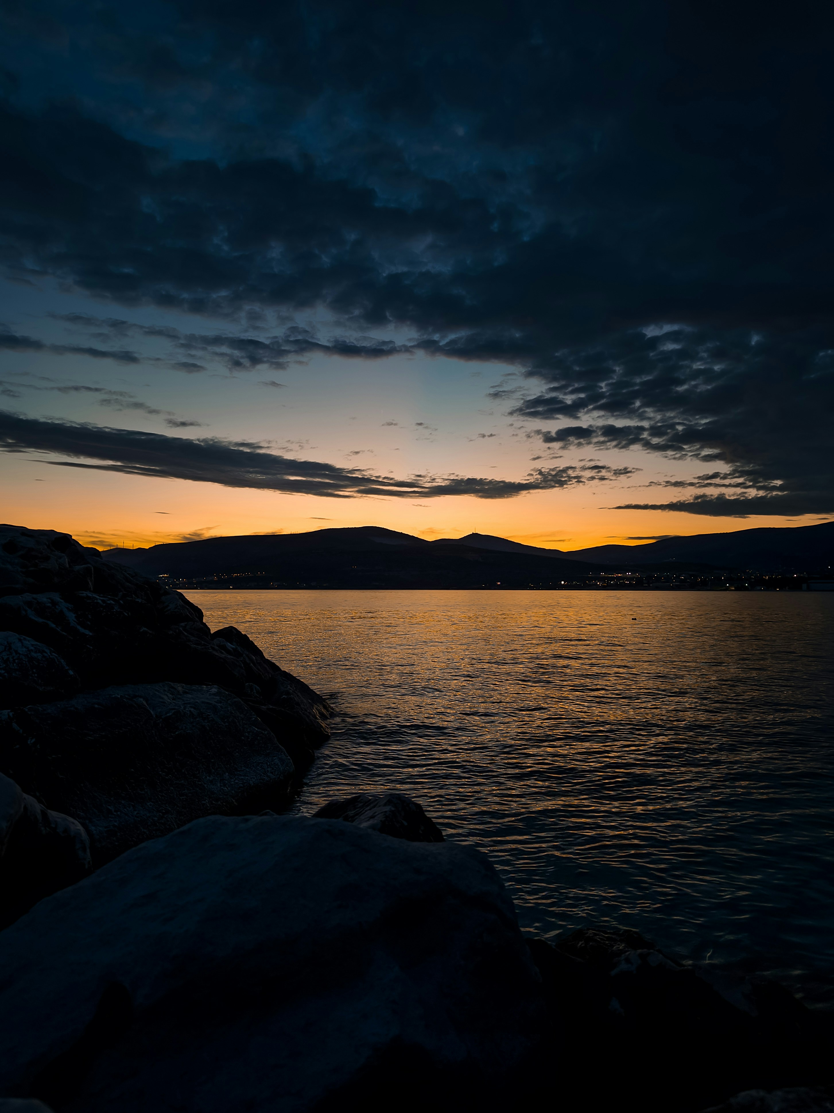Sunset Over Quiet Waters: A Dark Shore's Glow
