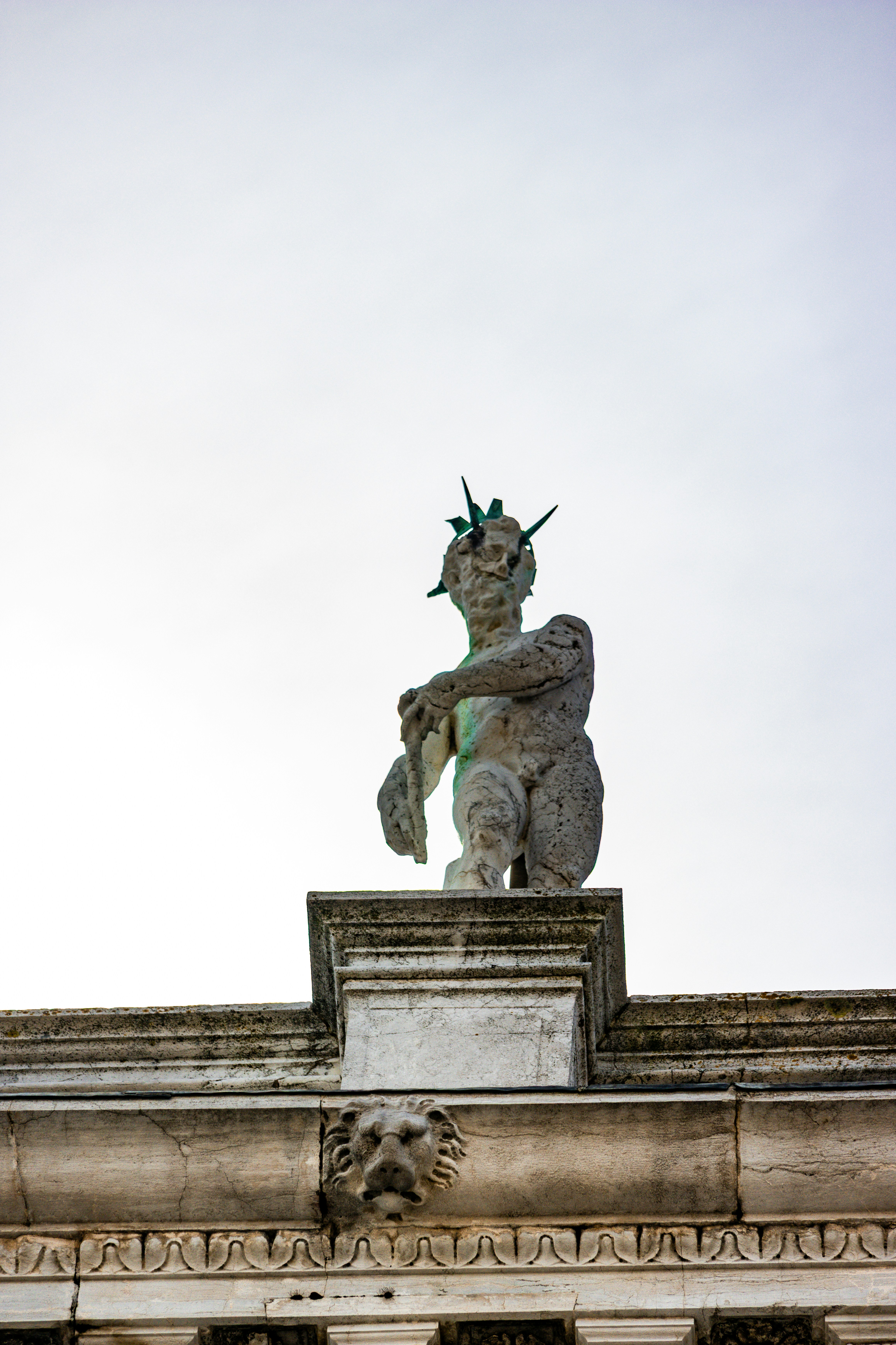 Statue of the Griffin-Topped Monument Guarding a Silent Facade