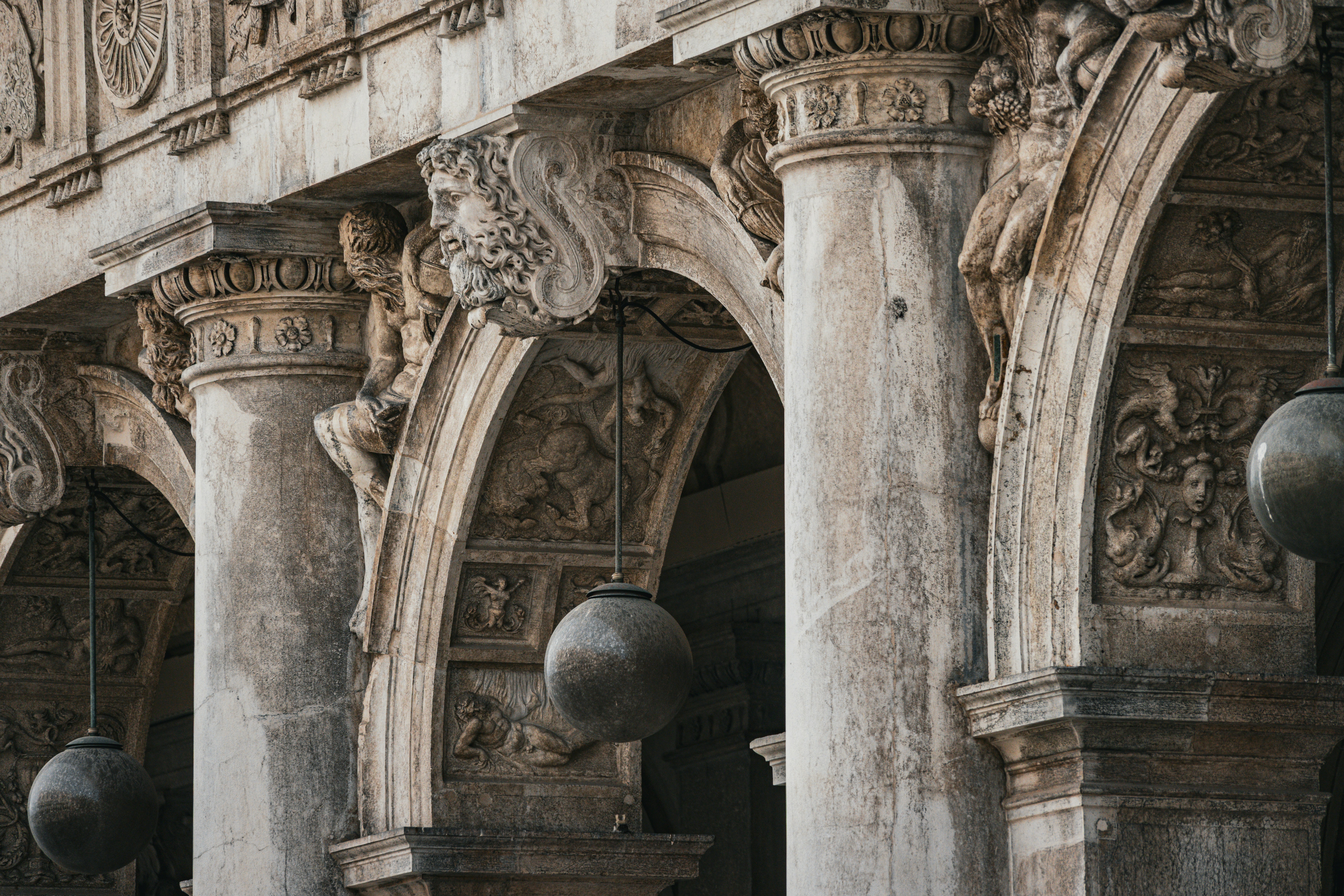 Carved Stone Facades and Sculpted Columns in a Historic Arcade