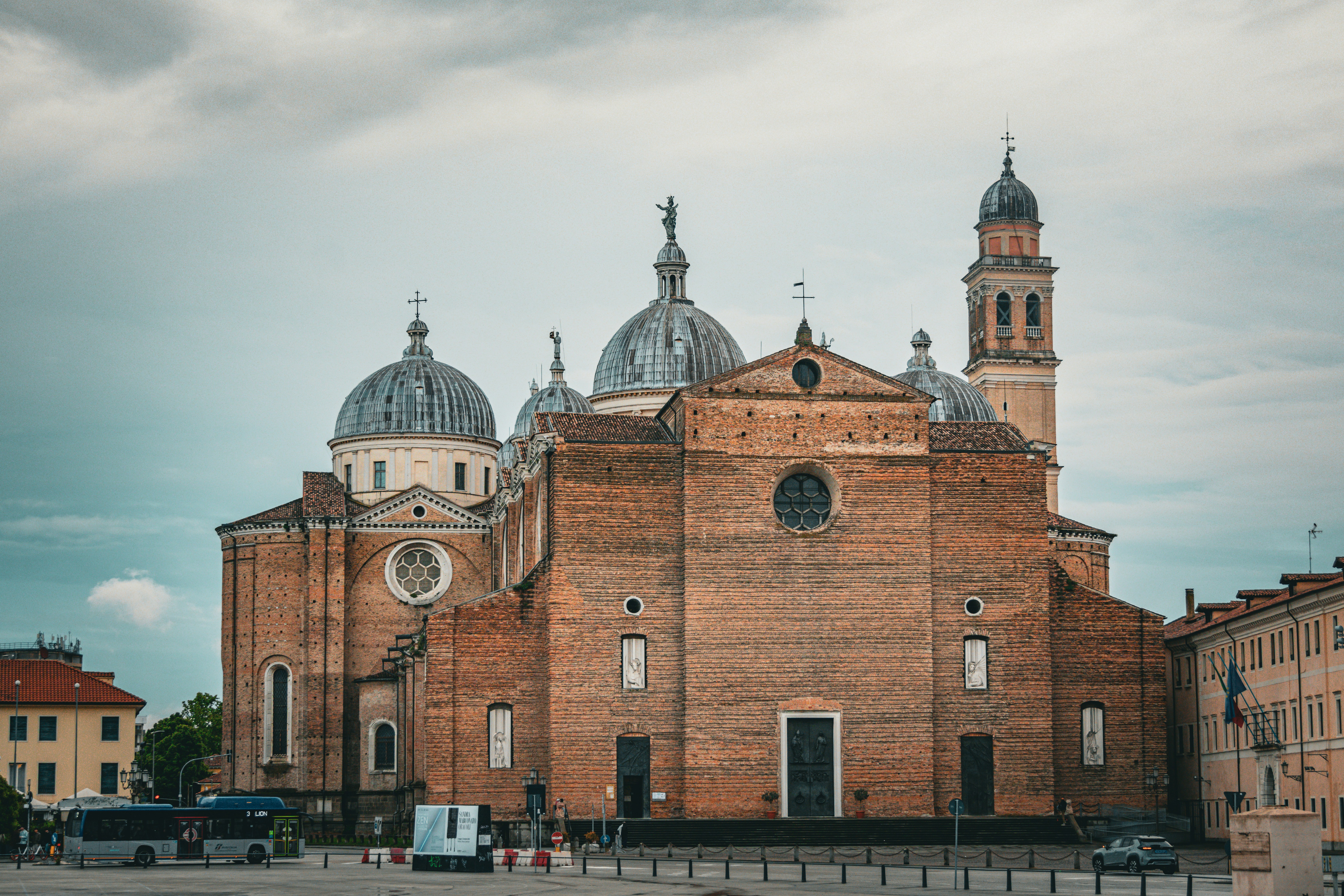 The Basilica’s Brick Wake: Dome and Bell Tower Over a Quiet Piazza