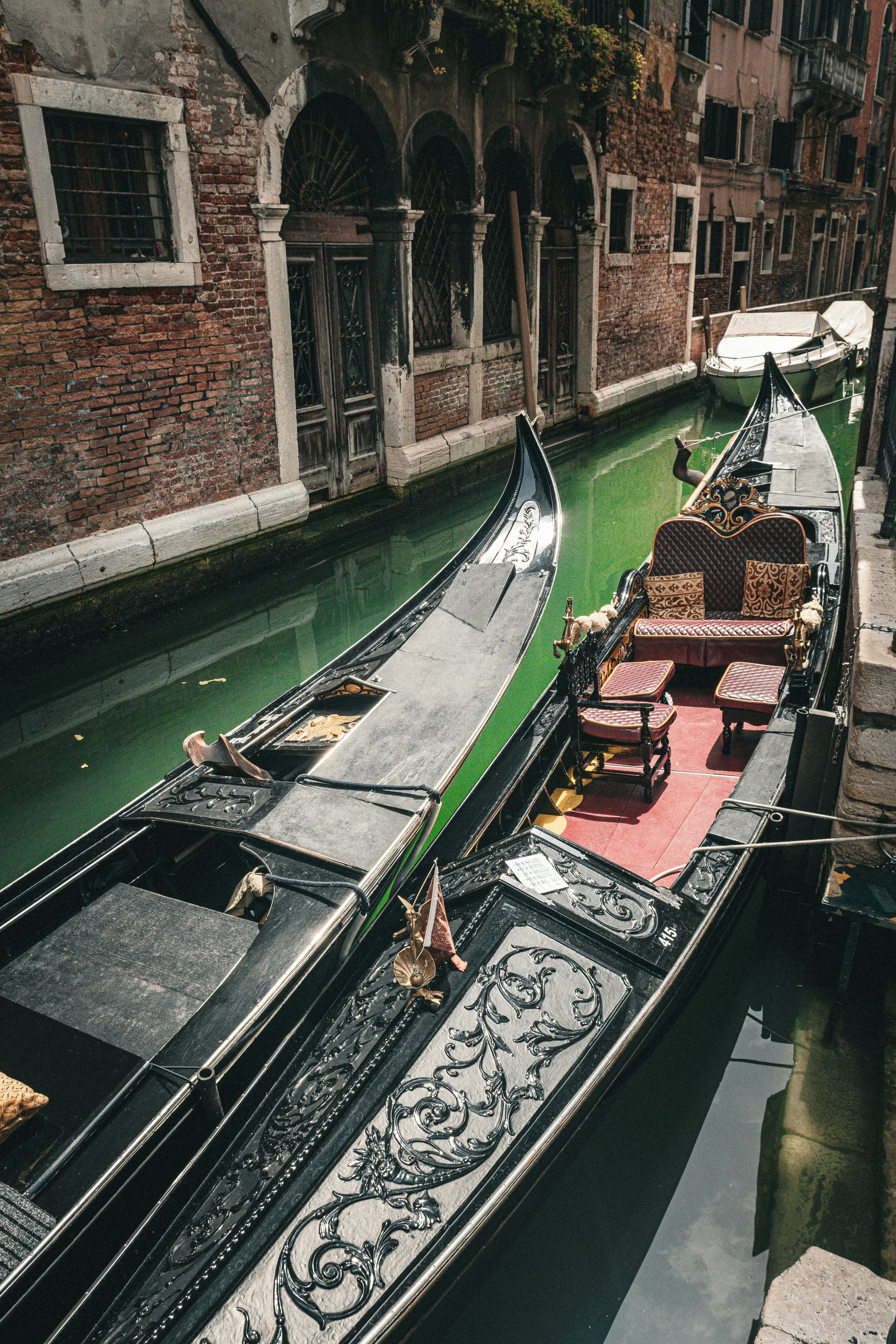 Gondola in a Venetian Canal: Ornate Craft Amid Weathered Brick
