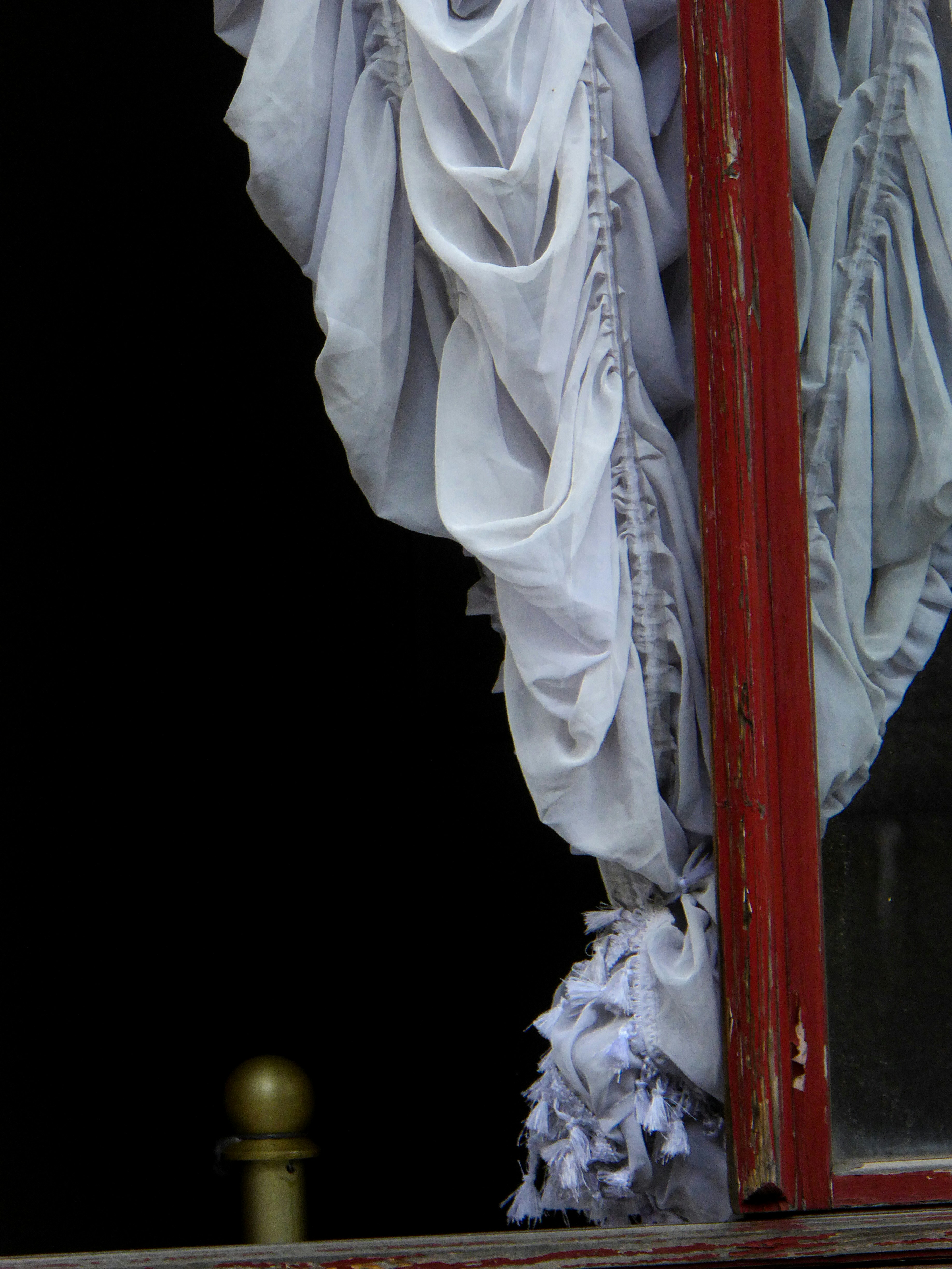 Red Curtain, White Fabric: A Quiet Still Life Through a Window