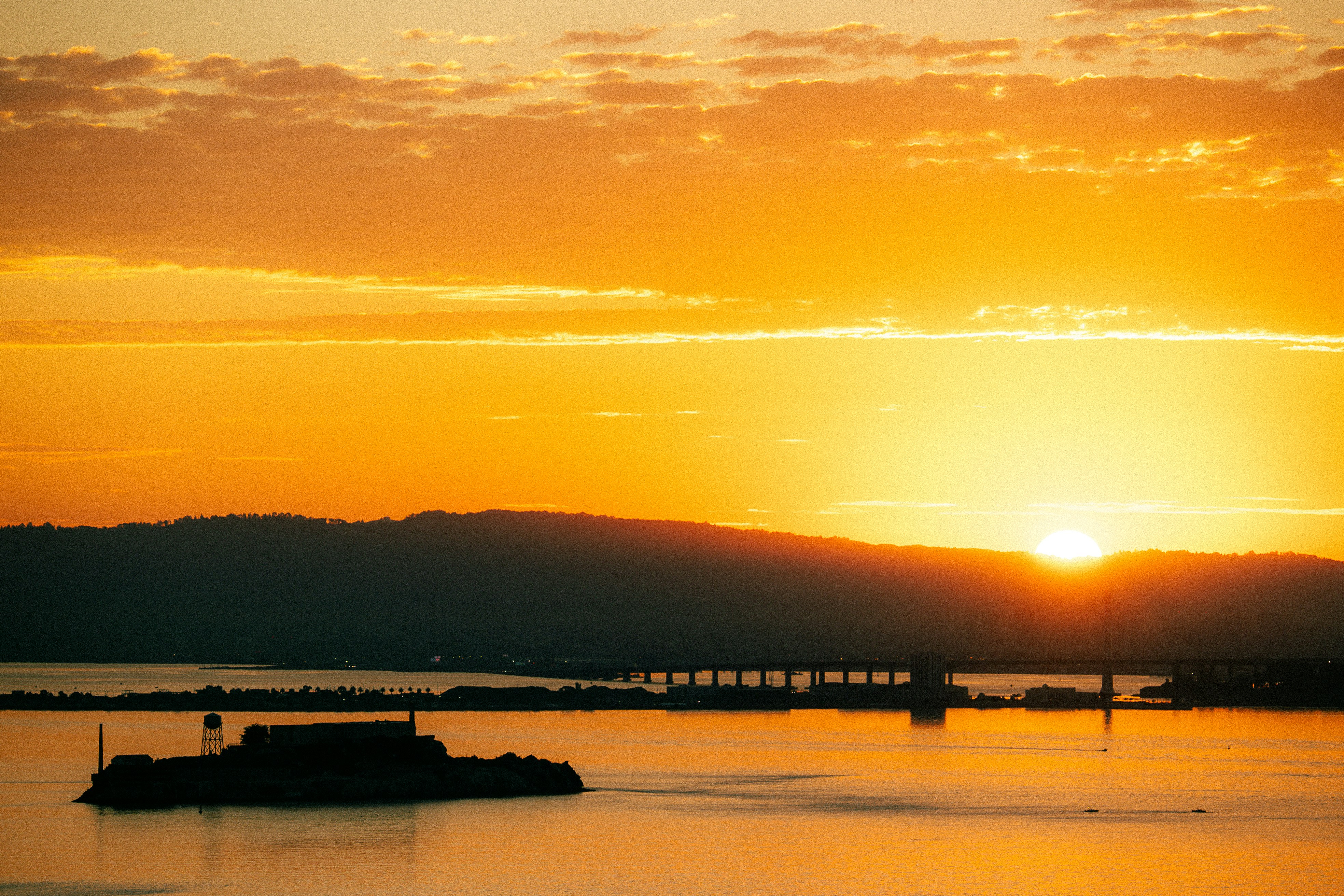 Sunset Over a Quiet Waterway with Silhouetted Bridge