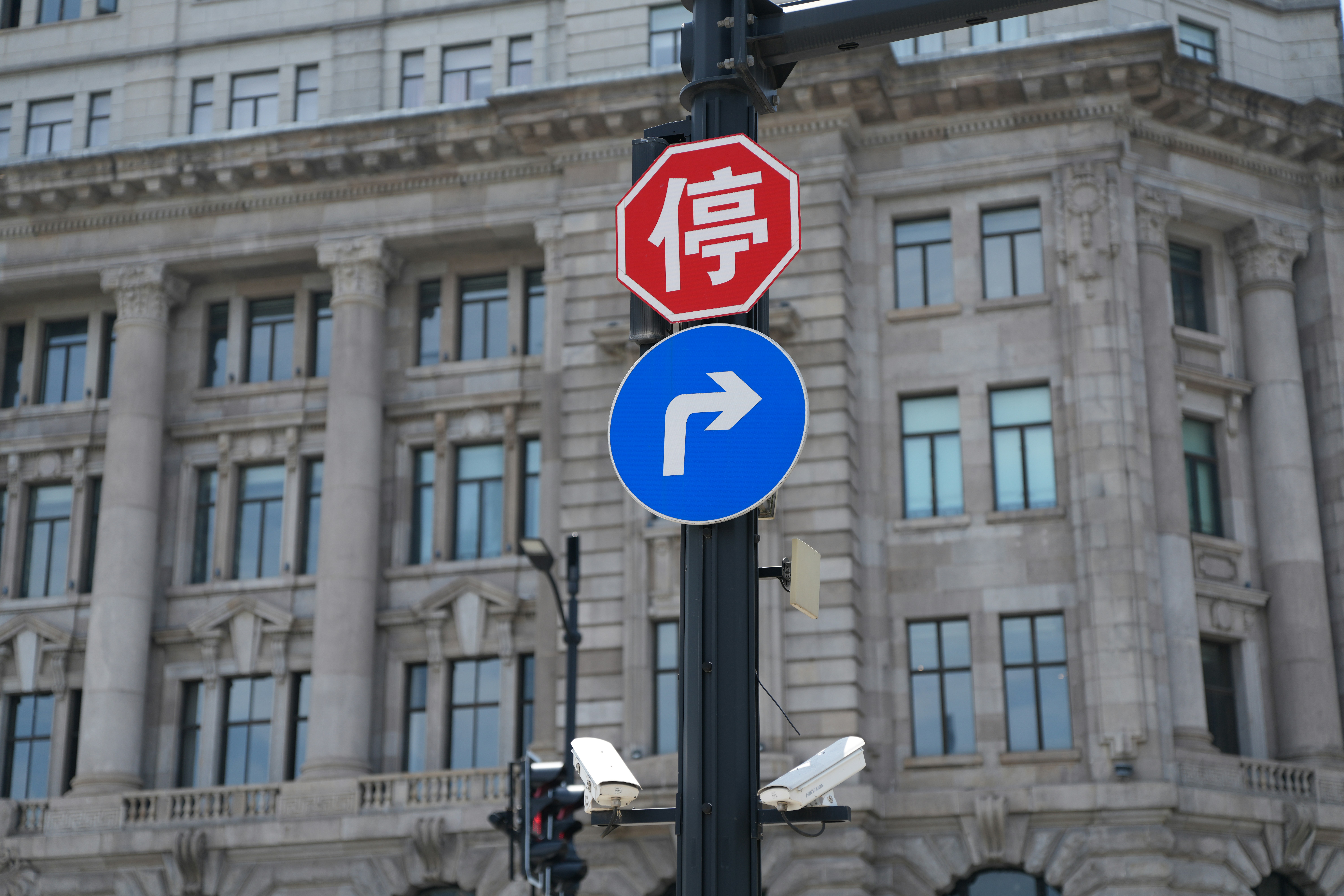 Stop Sign Over a Historic Facade: Traffic Signals at a City Corner