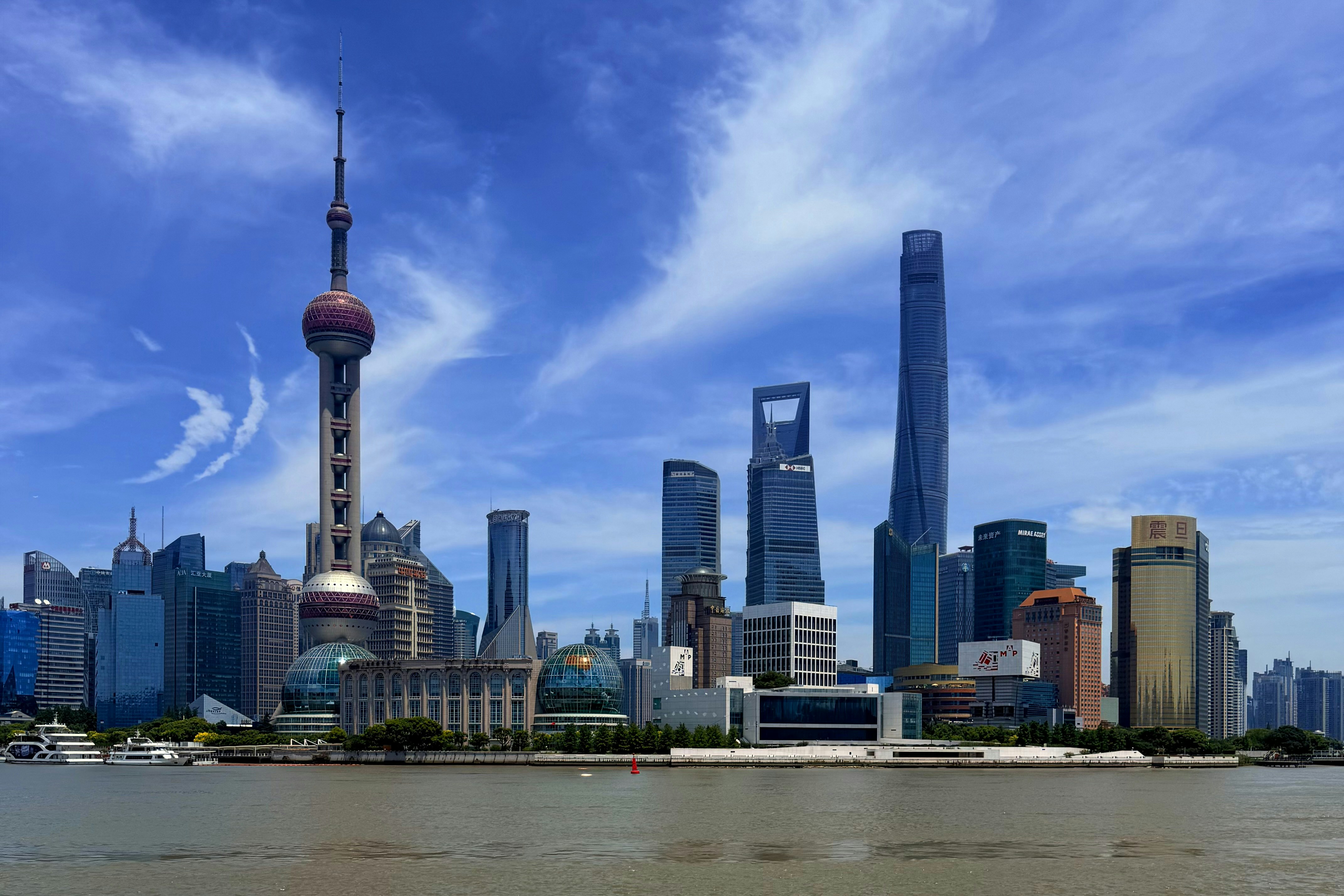 Skyline at the River: The Bund Skyscrapers Framed by Riverside Light